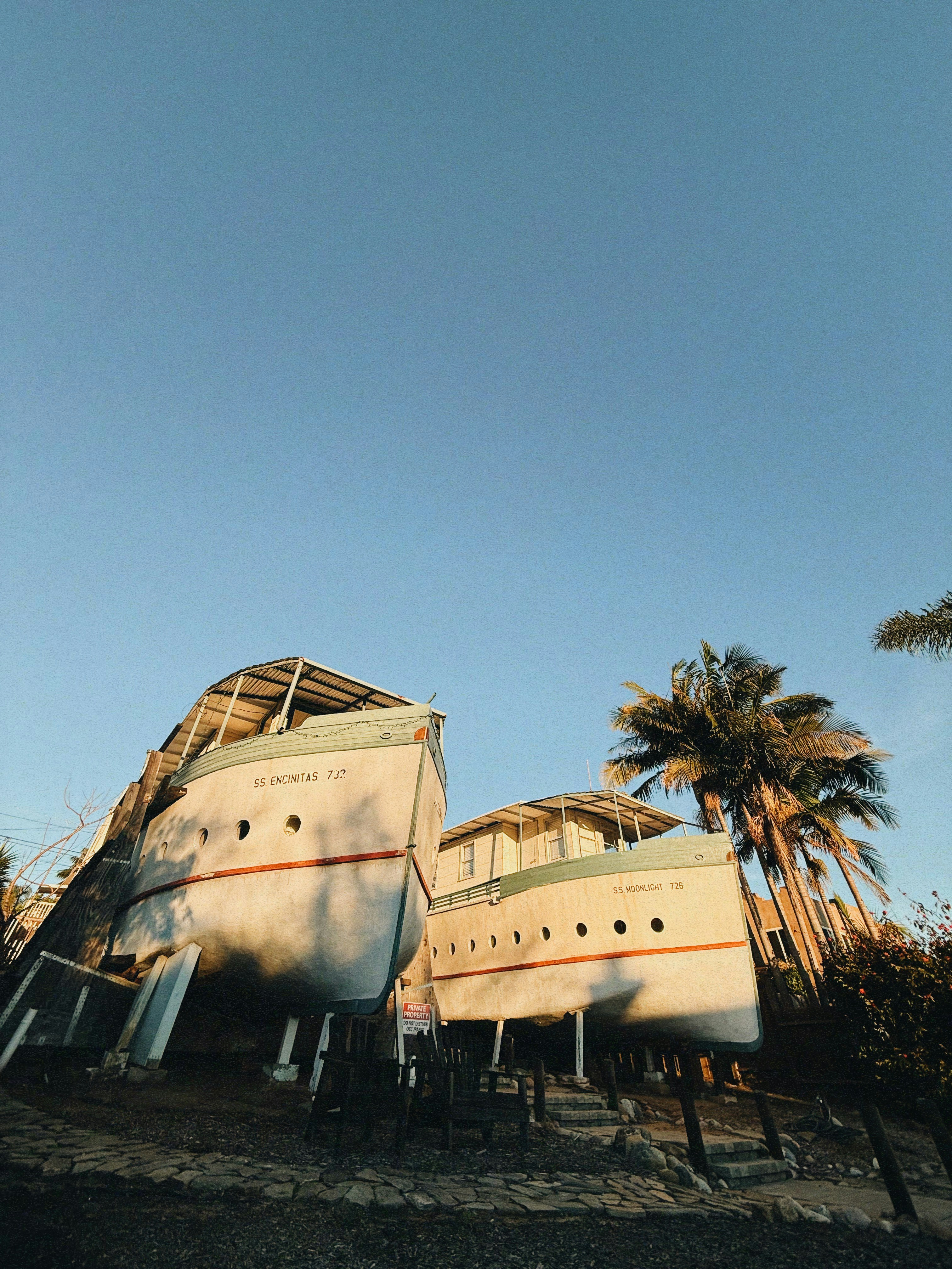 Beached Vessels: Boats Resting on Worn Stands Beneath a Quiet Sky