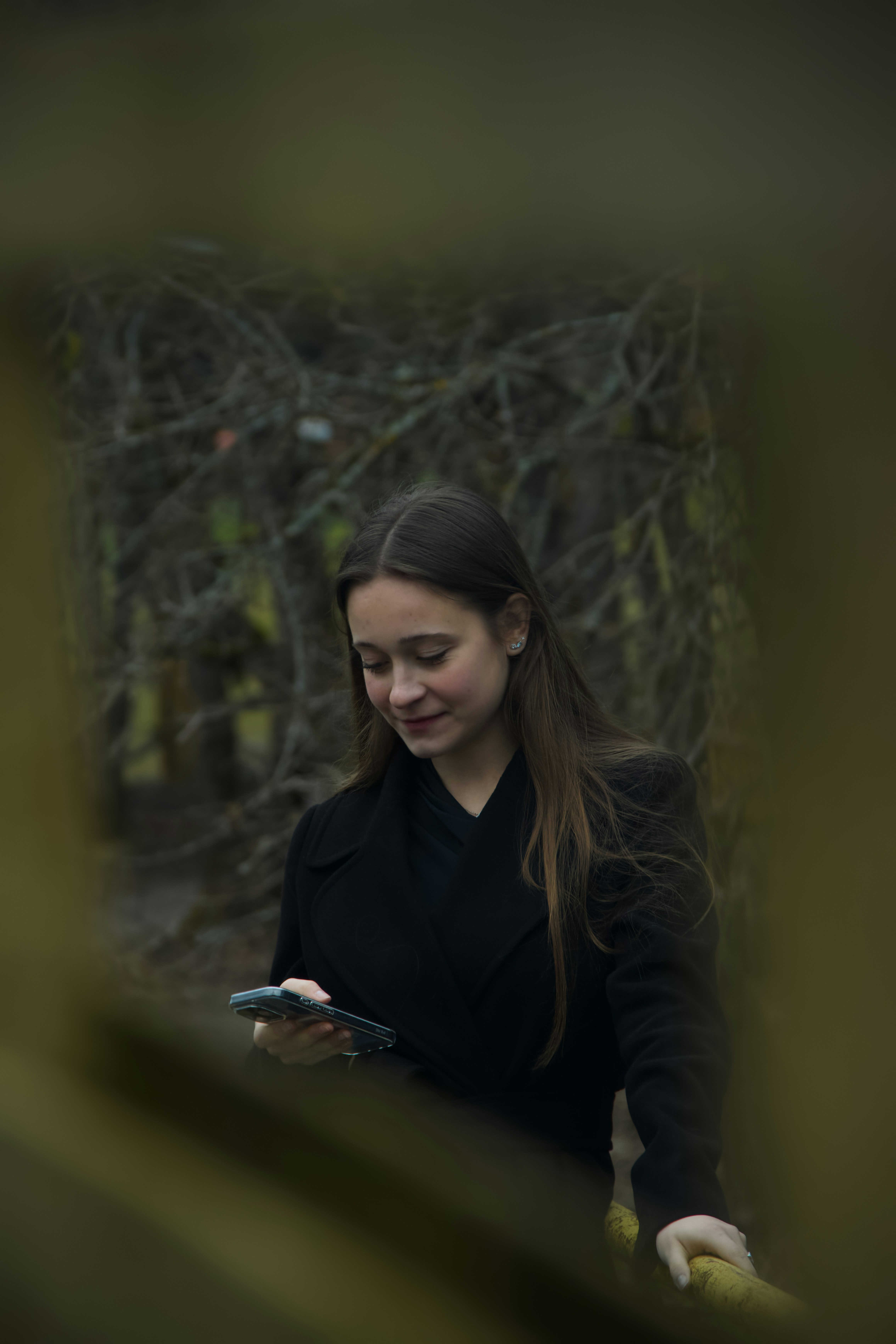 Portrait through a Wooden Frame: A Quiet Moment with a Smartphone
