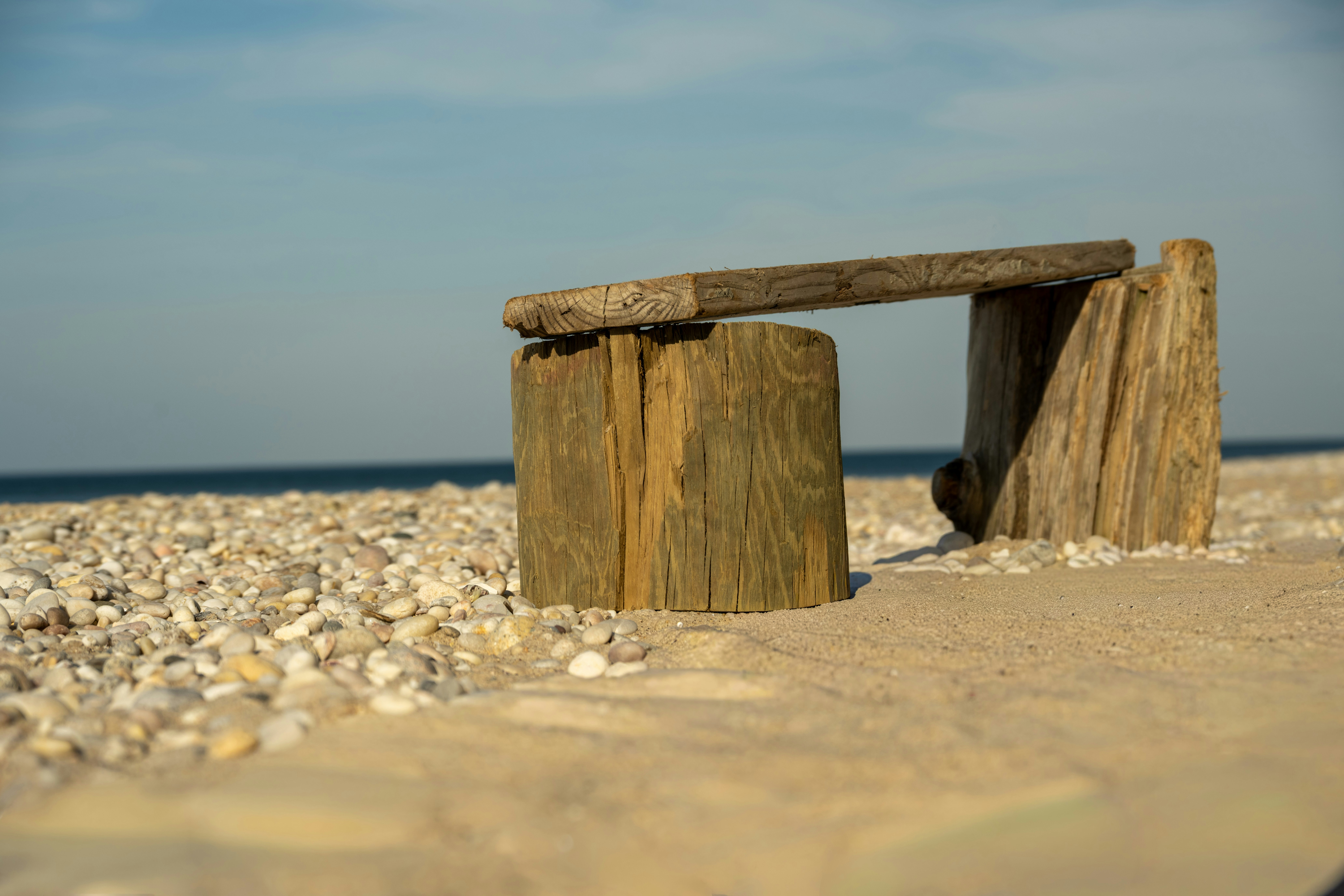 Weathered Beam on Pebble Shore: A Quiet Maritime Moment