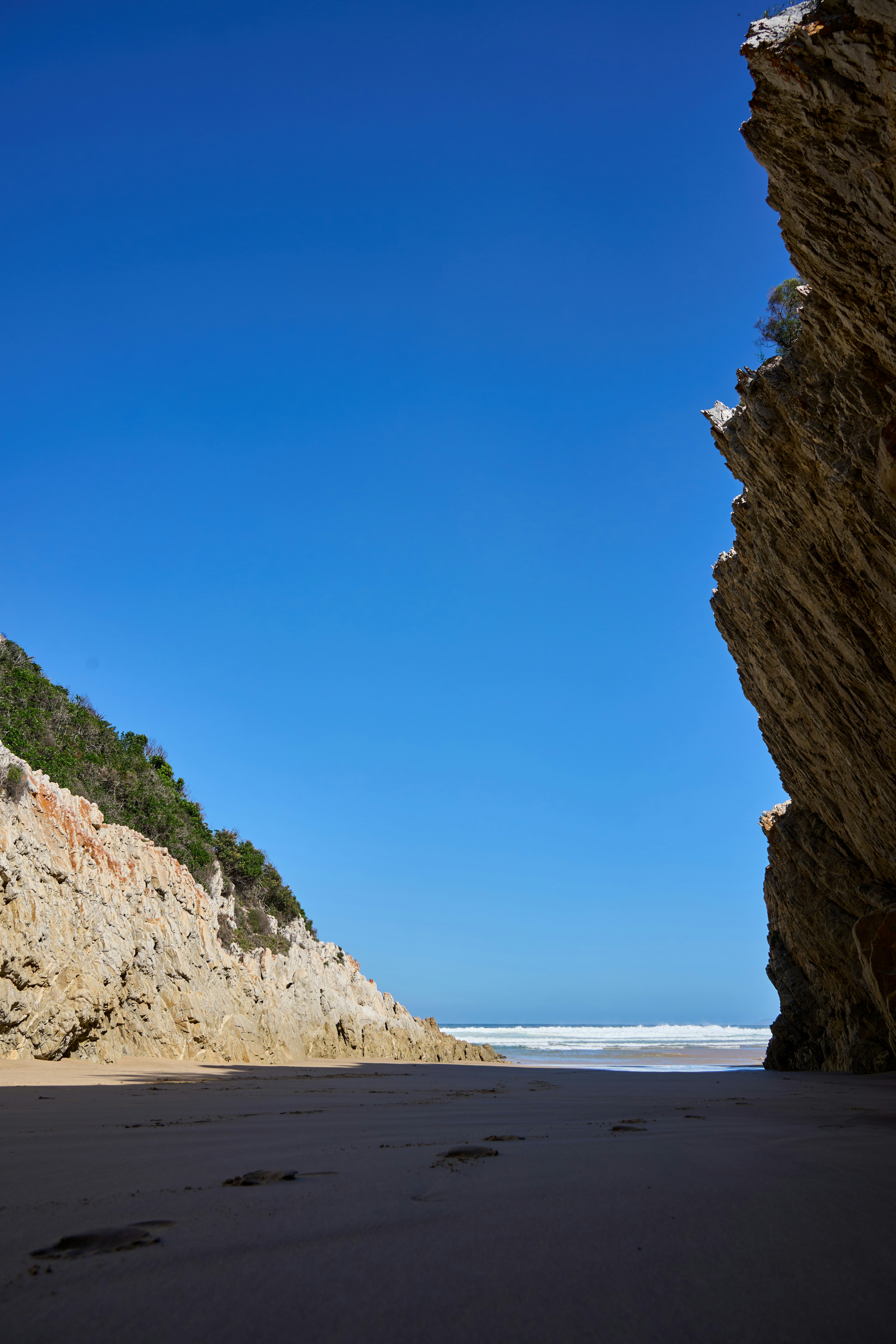 Cove Between Cliffs: A Quiet Beach Under a Clear Sky