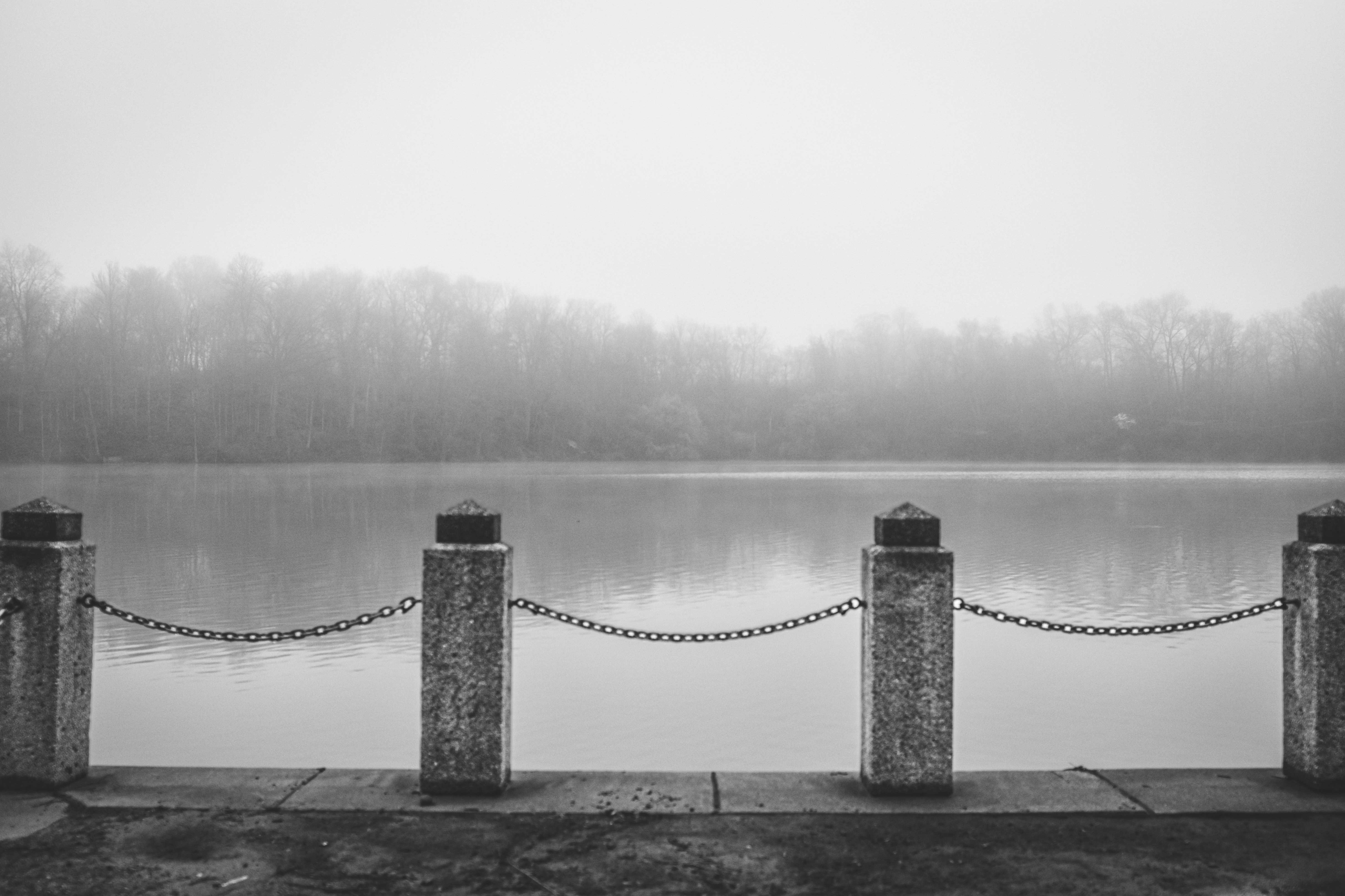Quiet Embankment at Dusk: Chains and Stone Pillars
