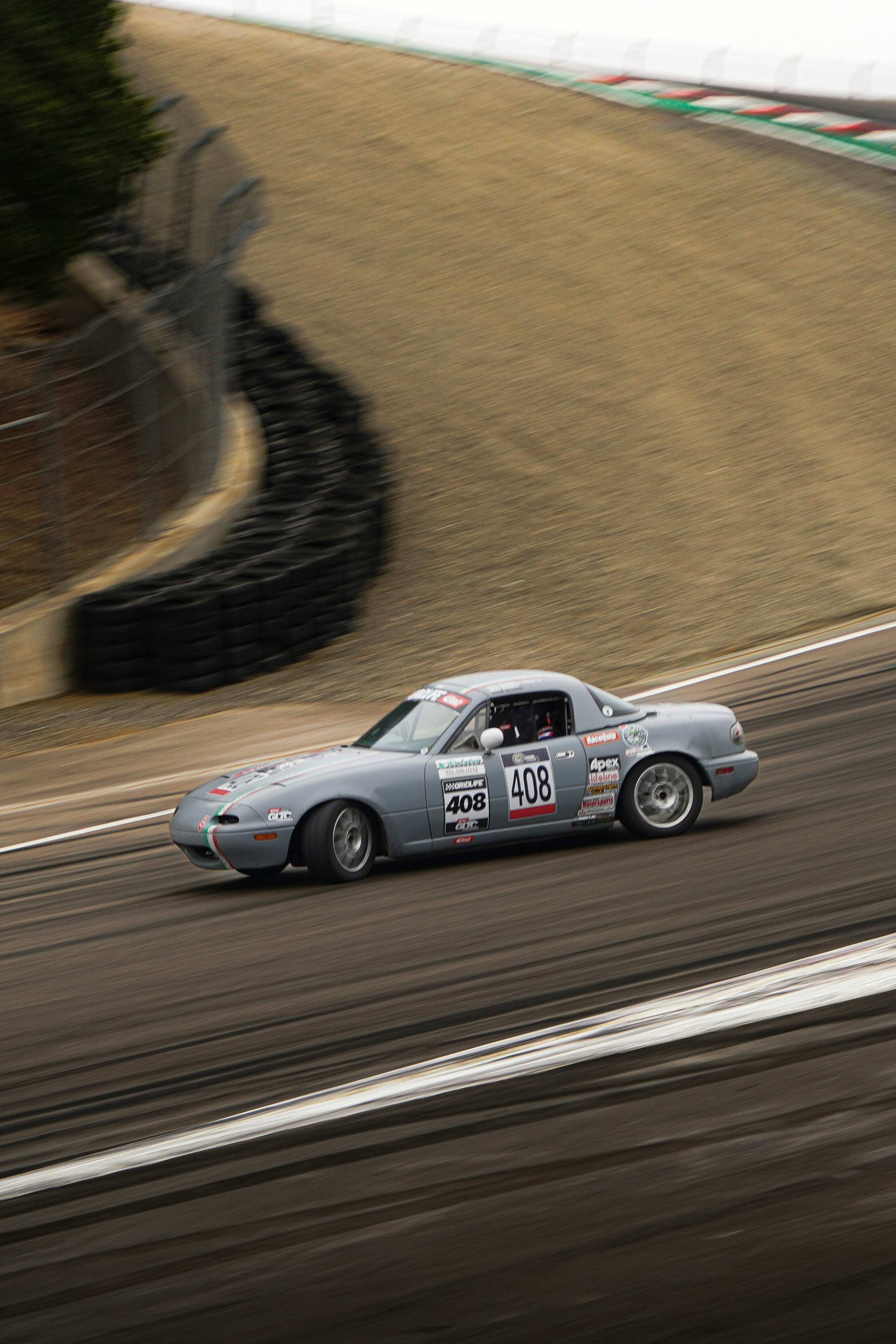 Silver race car carving through a curving track