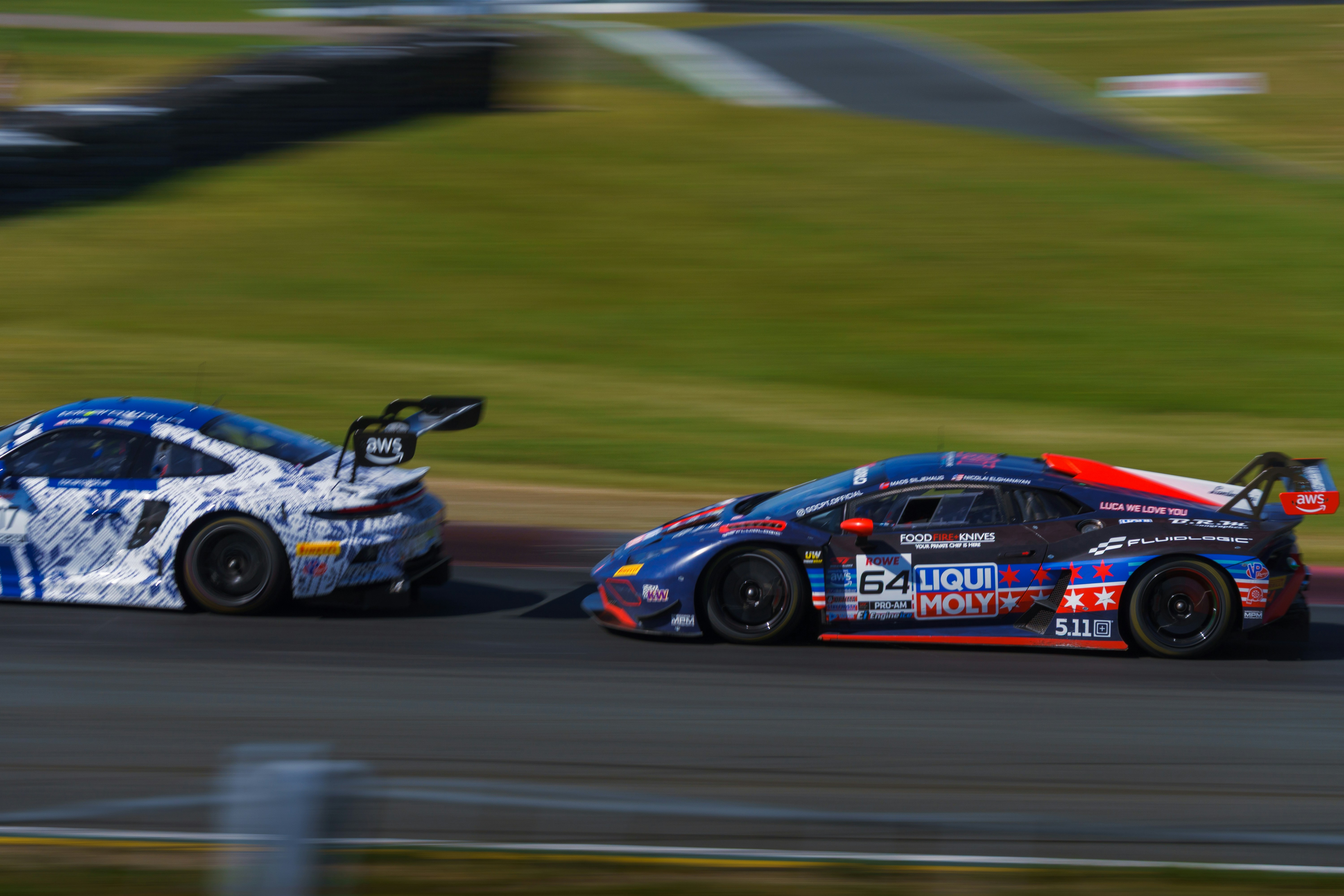 Gesturing duel: blue and white race car leads the chase on the sunlit track