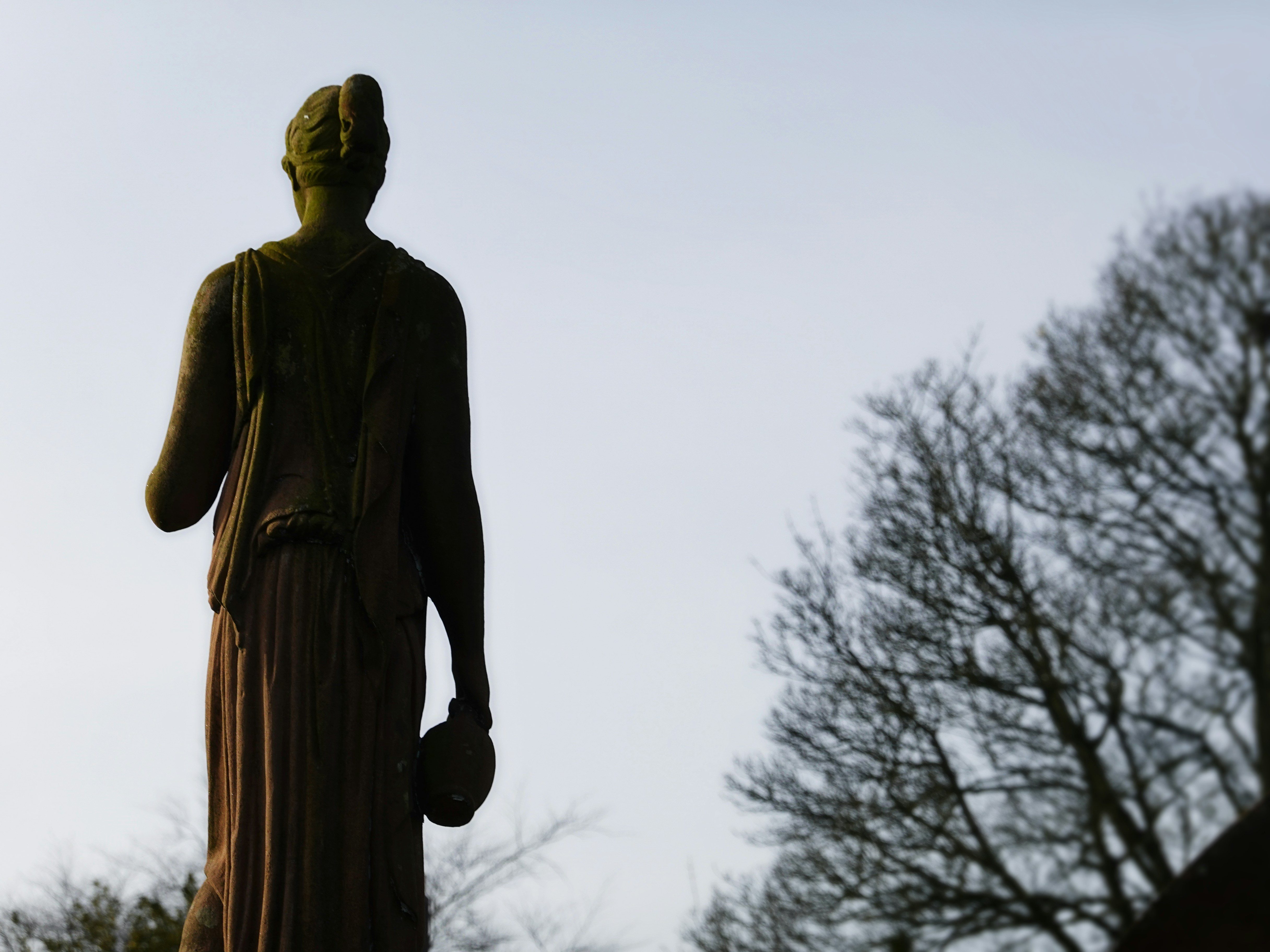 Silent Sentinel: A Statue Reaching Toward Winter Sky