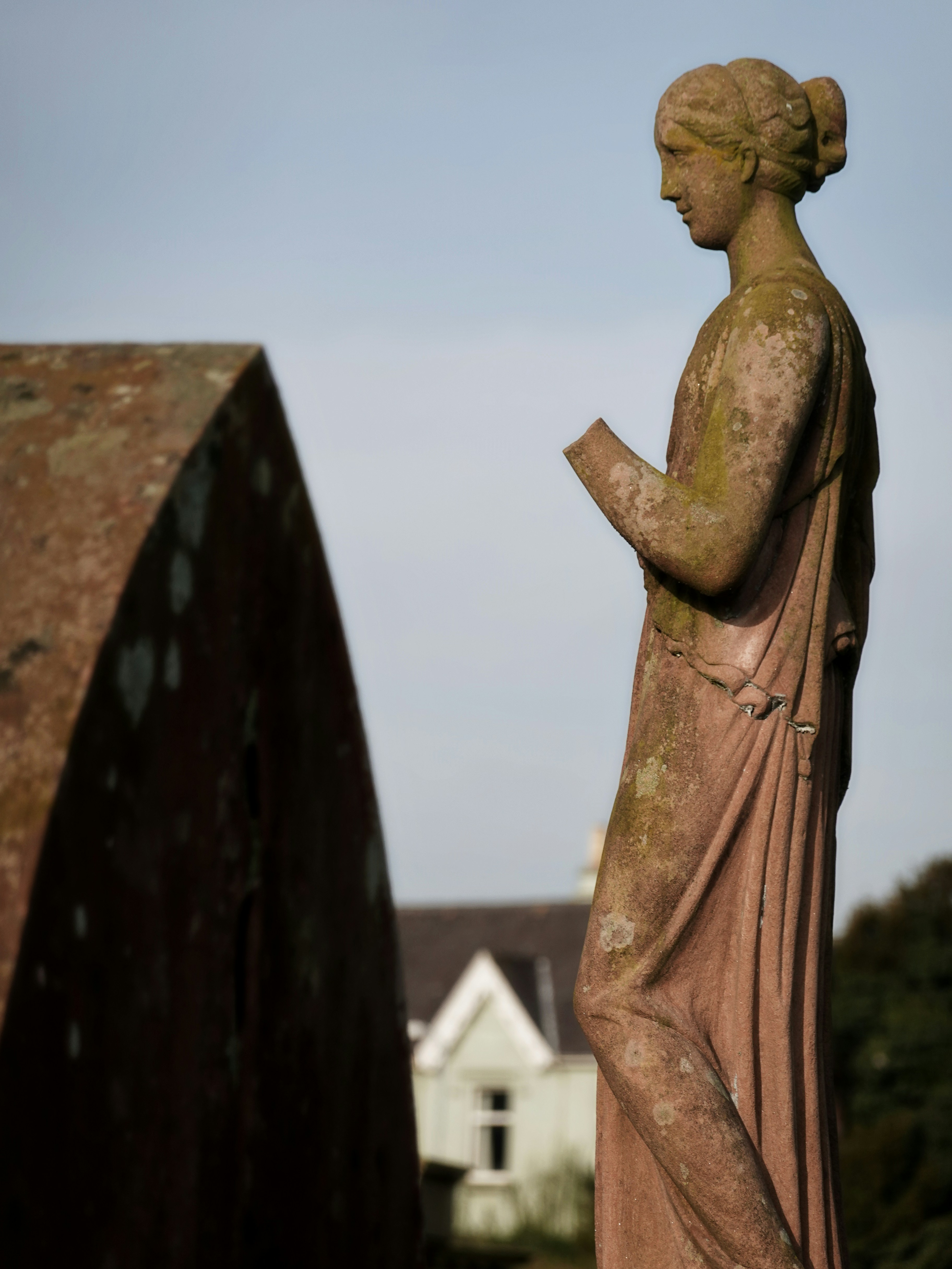 Weathered statue of a woman with a missing arm
