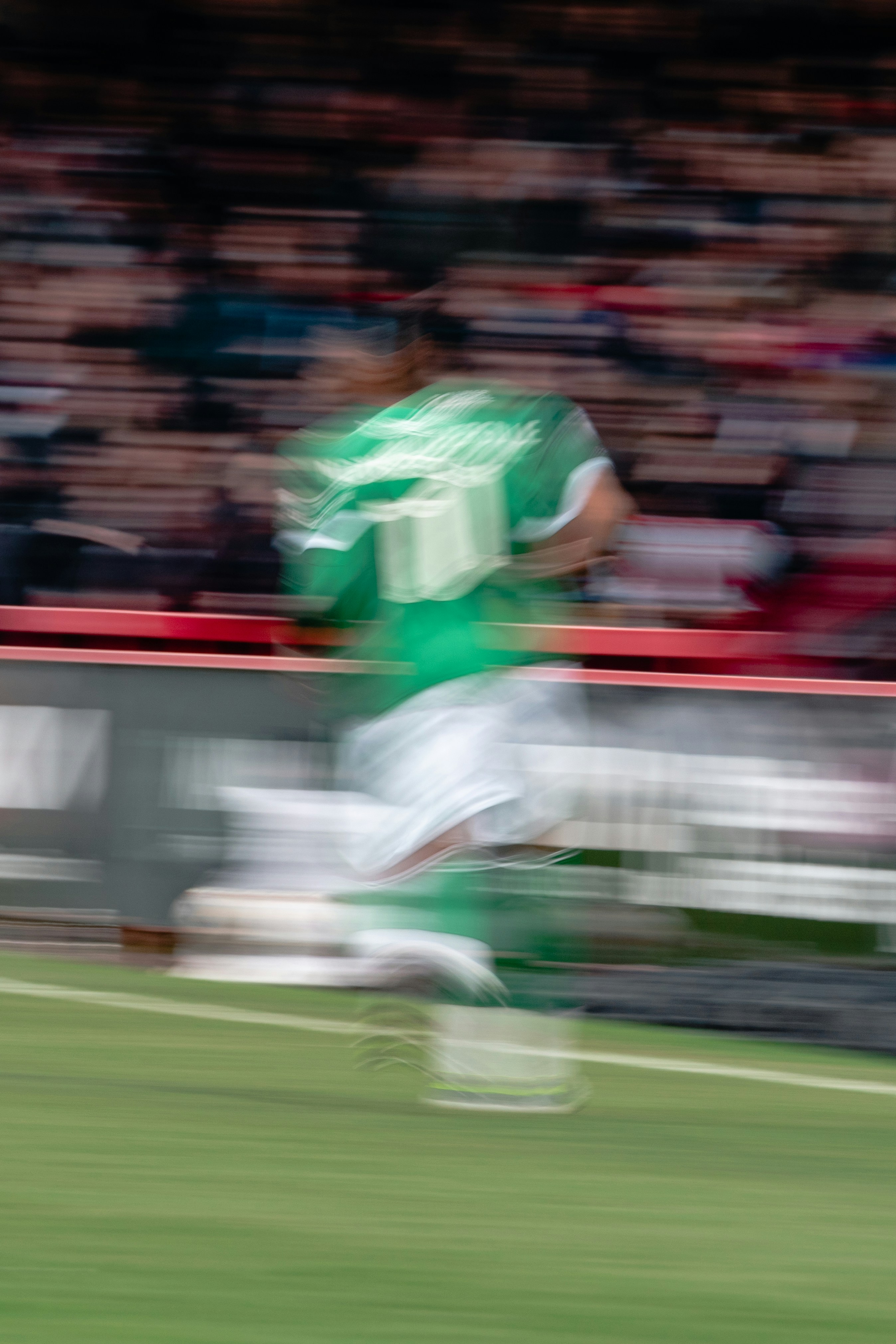 Green Hurdler in Motion: A Blur of Speed on the Field