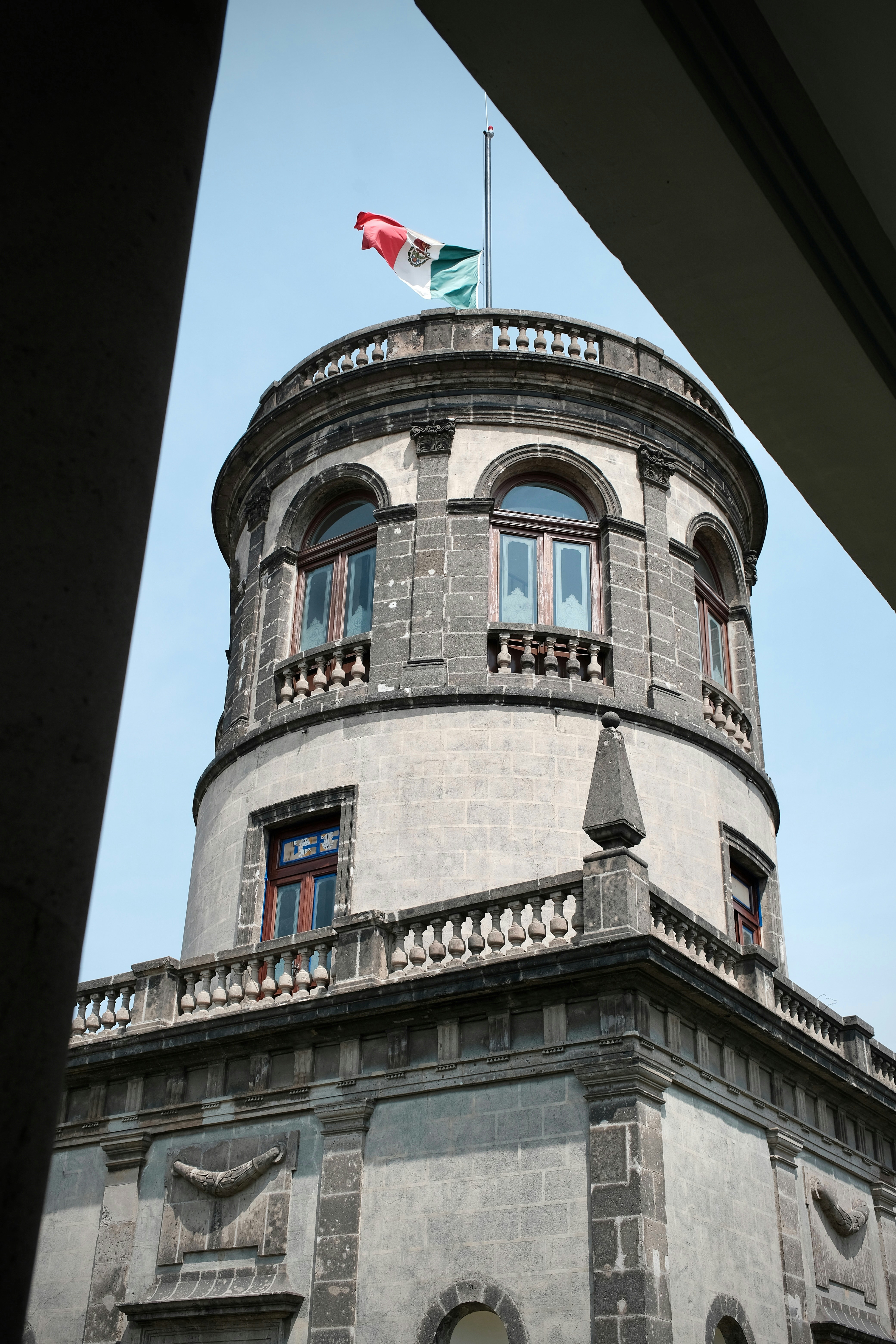Flag over stone turret: a monument framed by architectural shadows