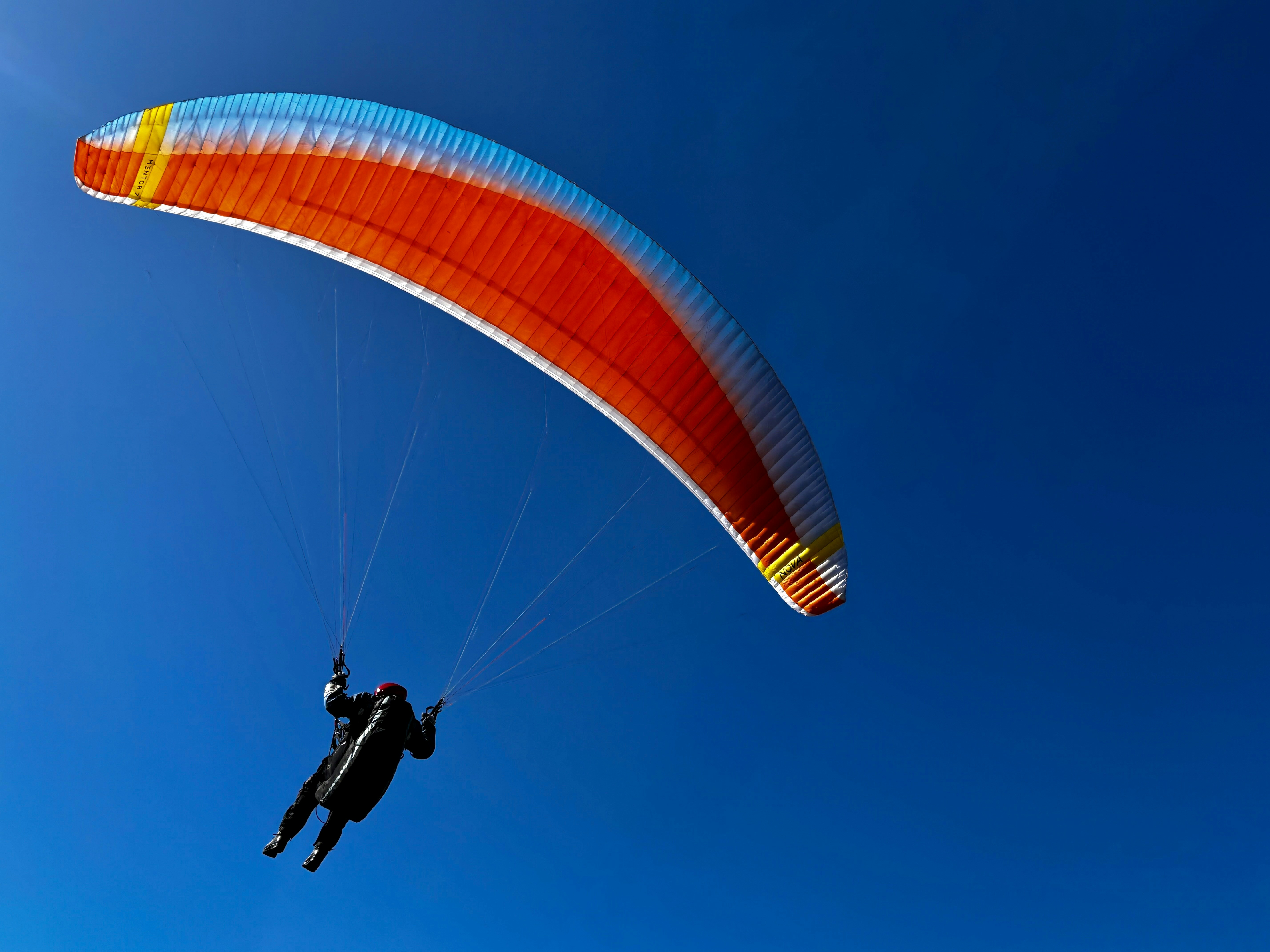 Skyward Axes: A Solo Paraglider Against a Velvet Blue Crest