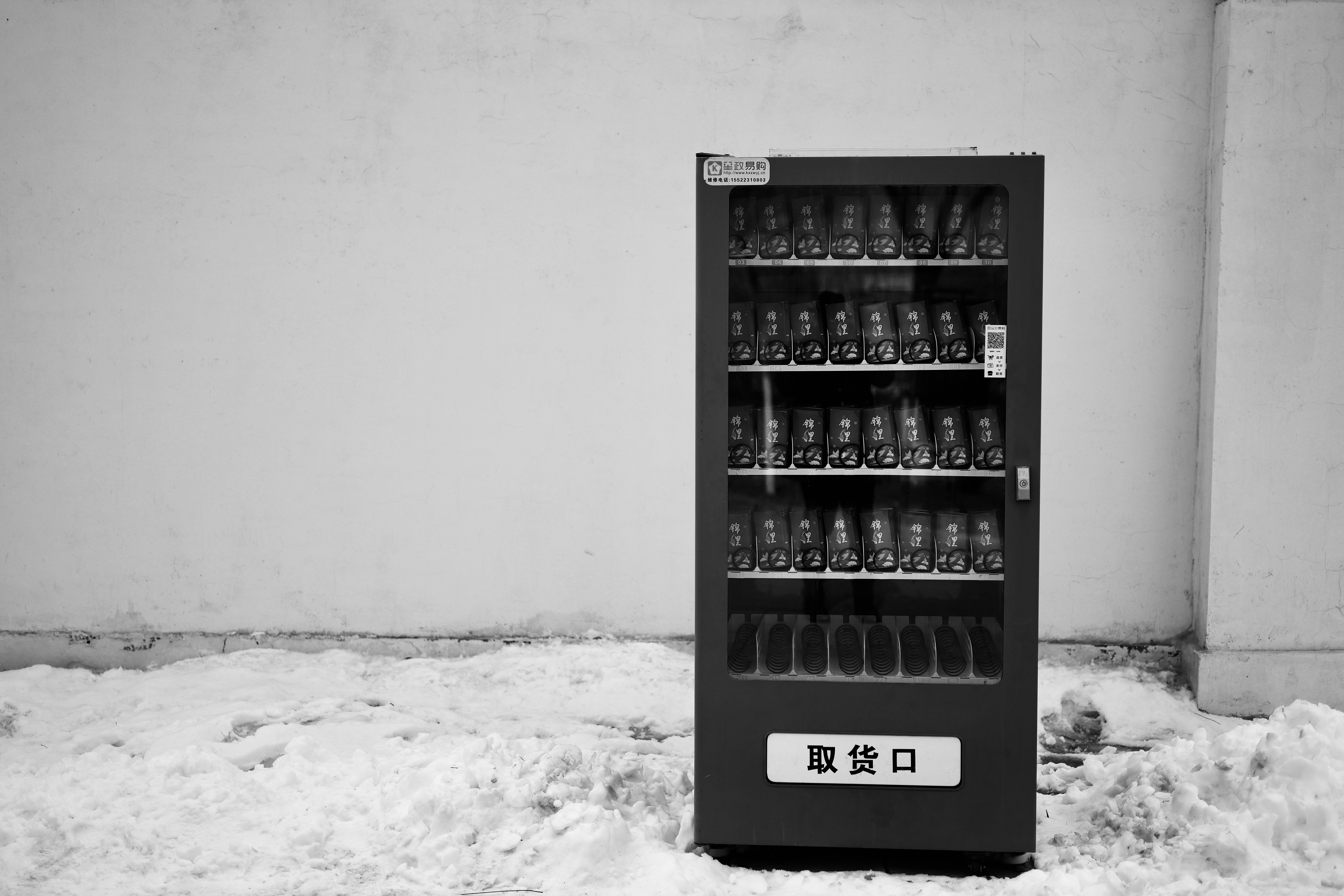 A lonely vending machine standing sentinel in a snow-swept courtyard