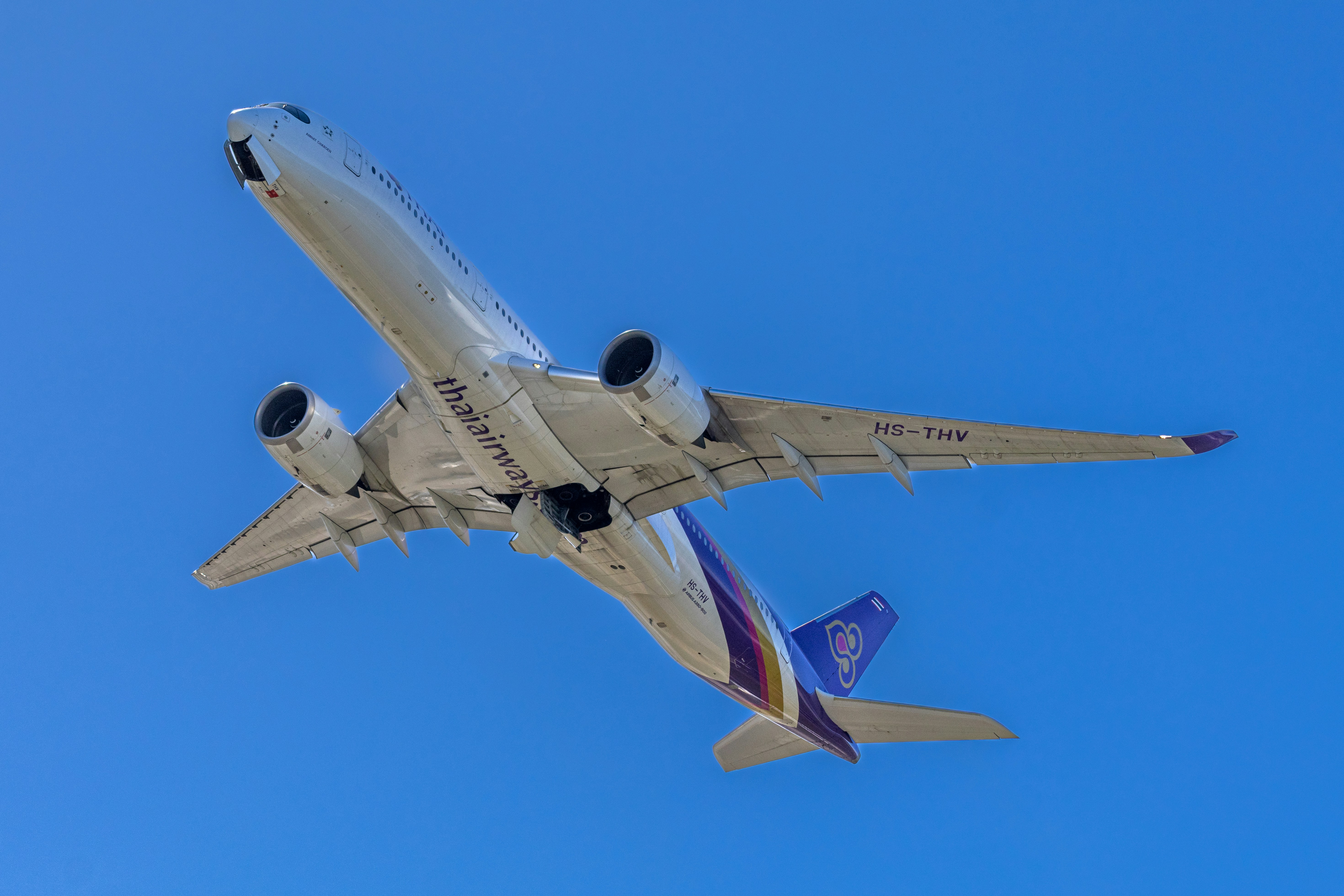 White jet cutting through a bright blue sky