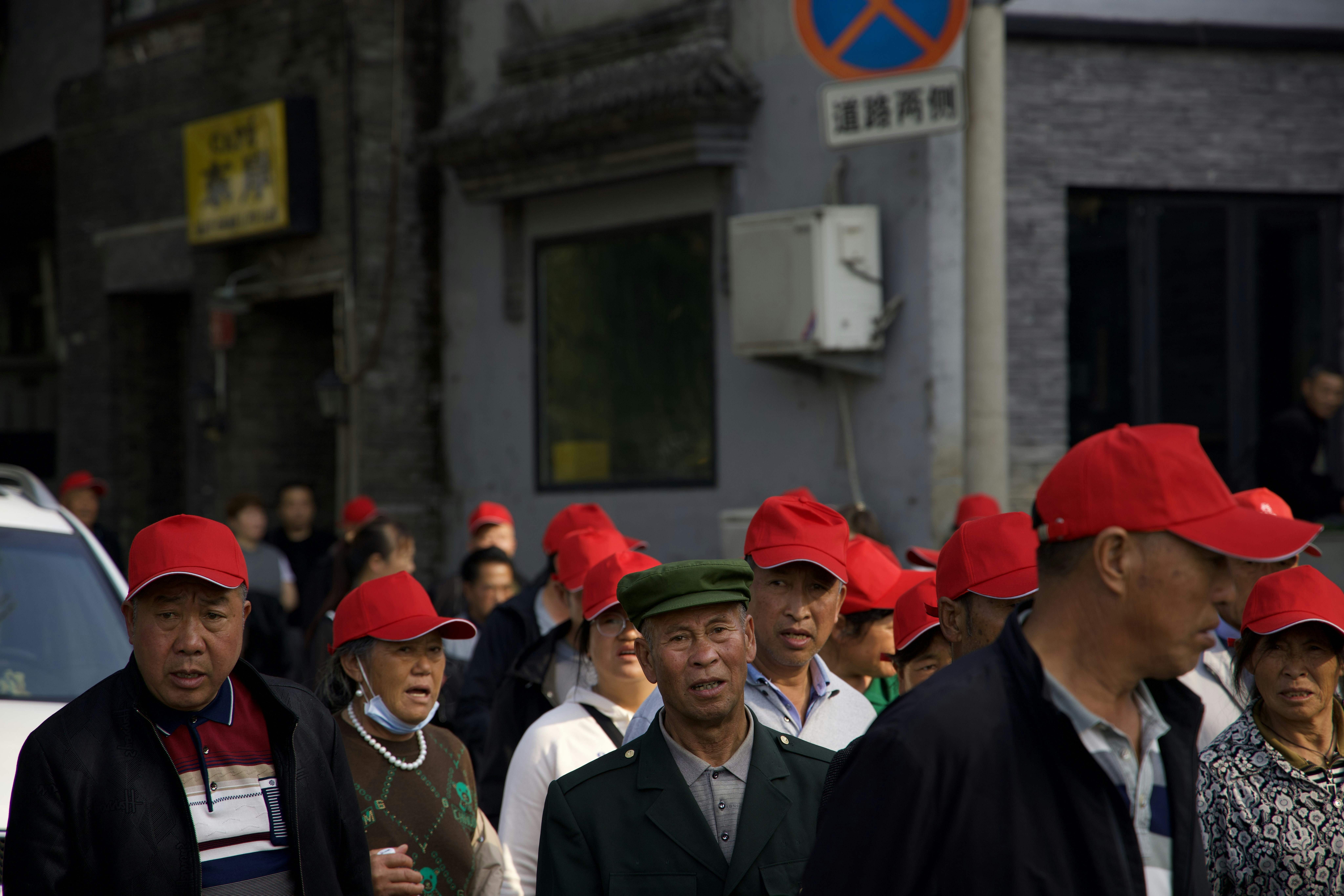 Red-Capped Procession: A Street Crowd Moves Through an Urban Scene