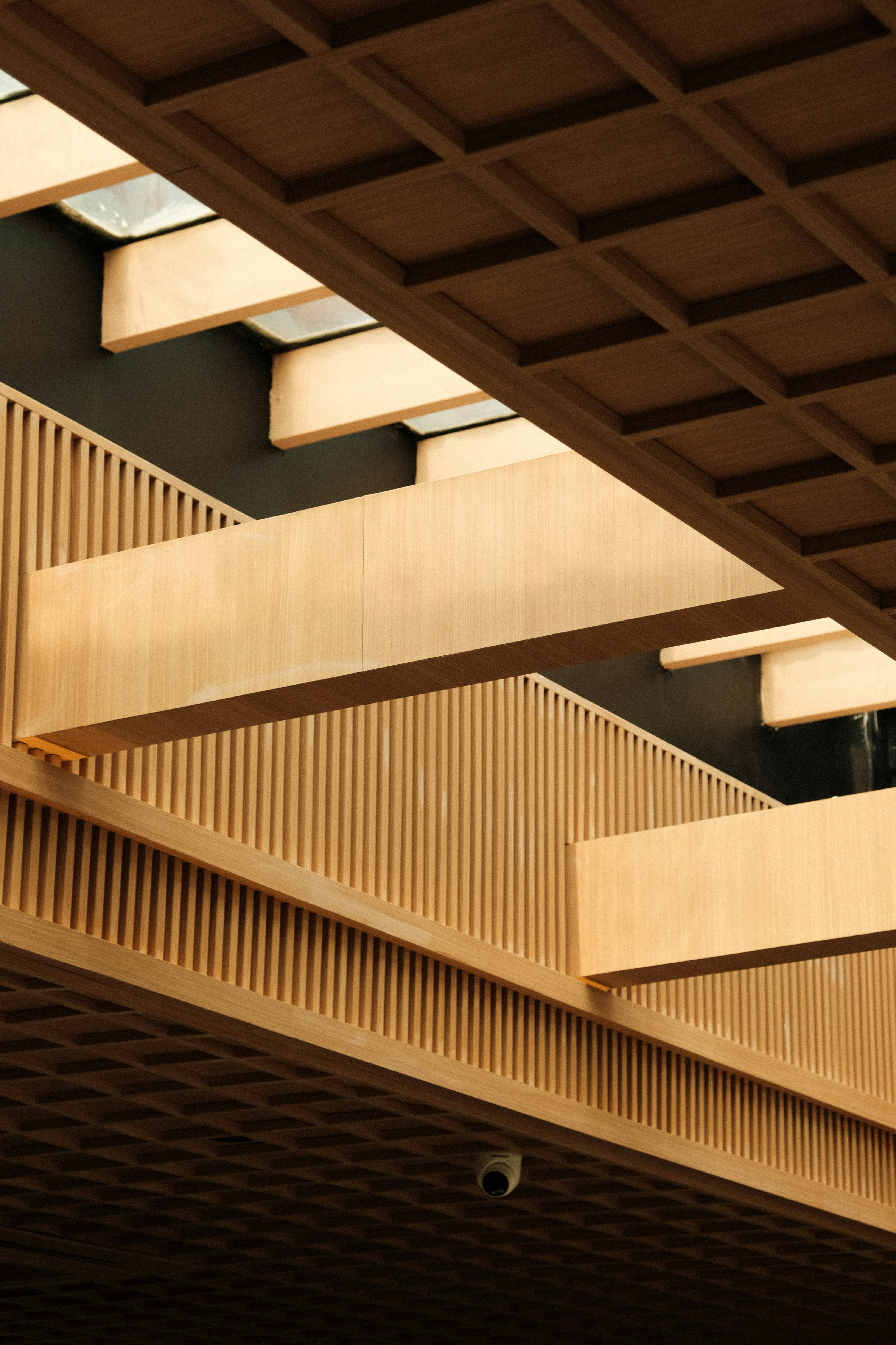 Geometric Warmth: Golden Wood Ribs in Overhead Architecture