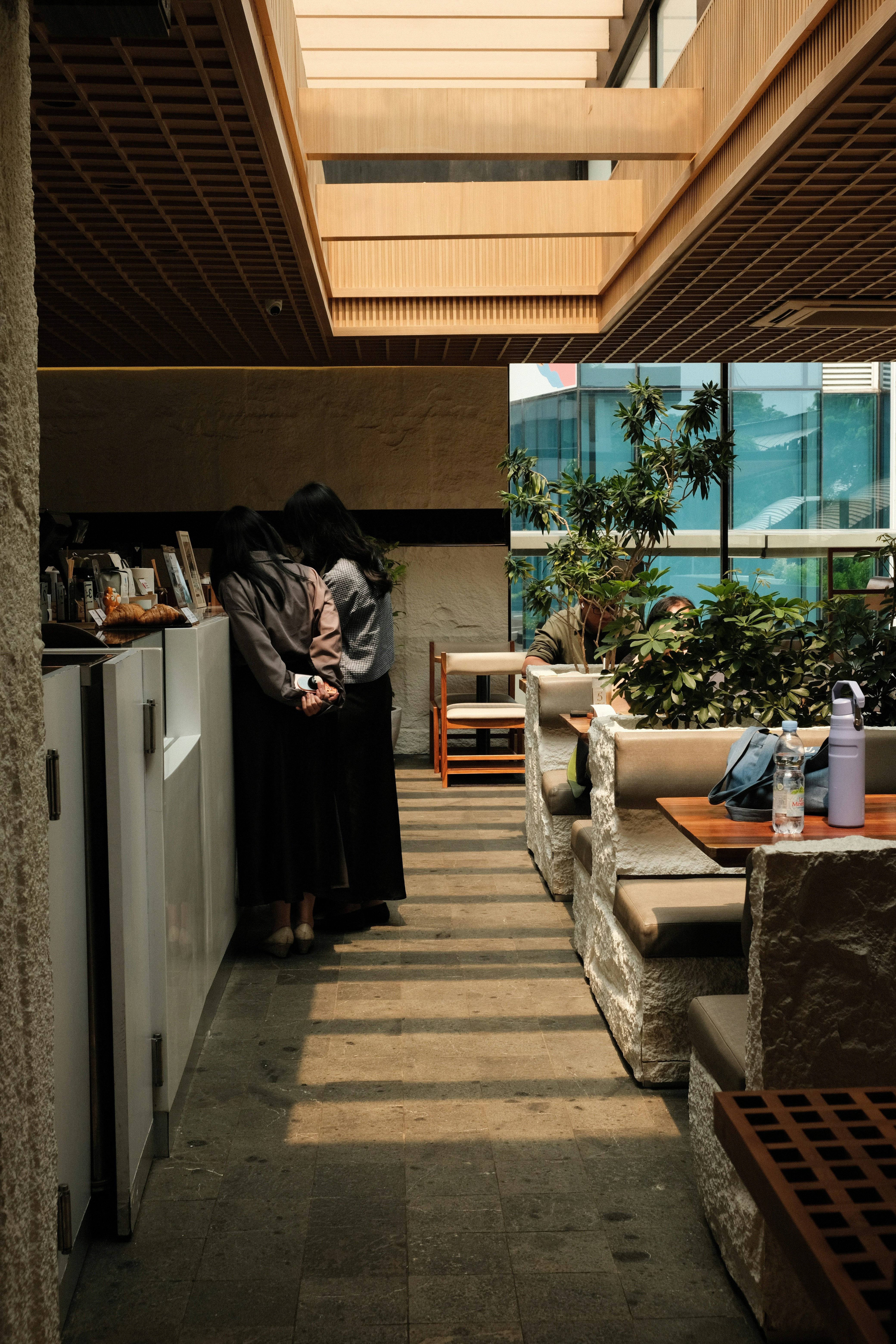 Quiet Convergence: People at the Beverage Counter in a Modern Atrium