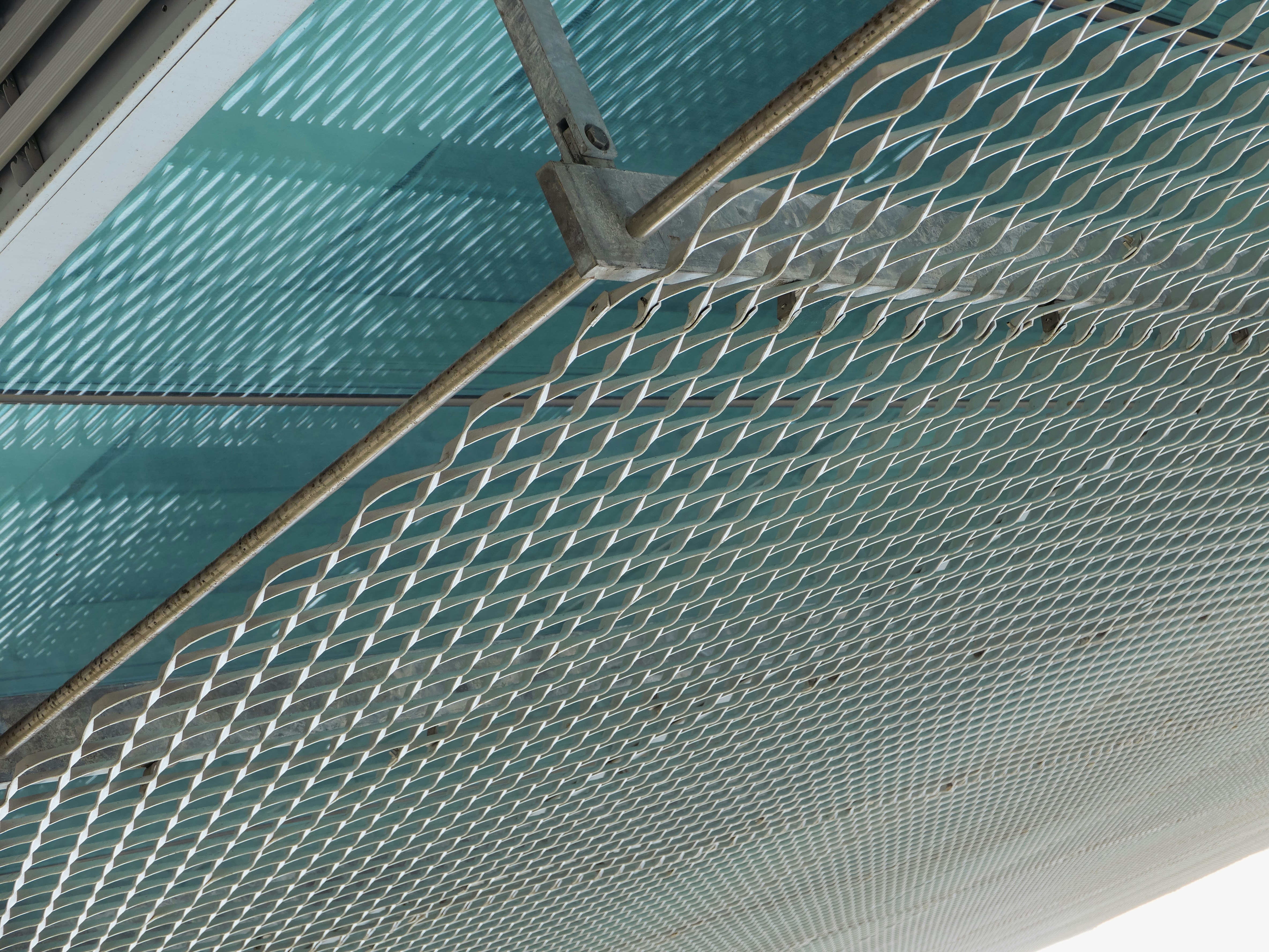 Chained Perspective: Diamond Mesh Against a Teal Tunnel
