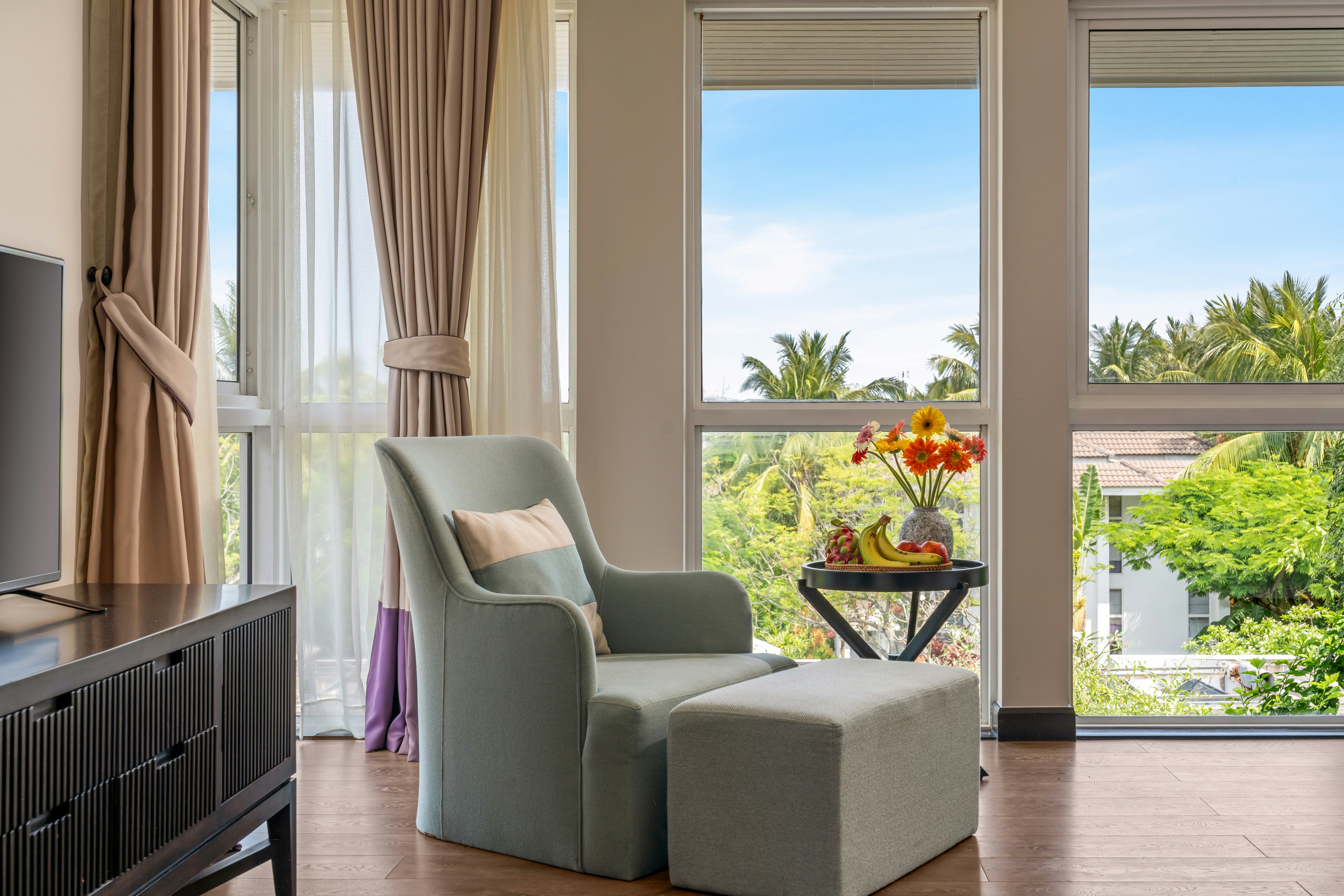 Sunlit Living Nook with Upholstered Chair and Ocean-View Windows