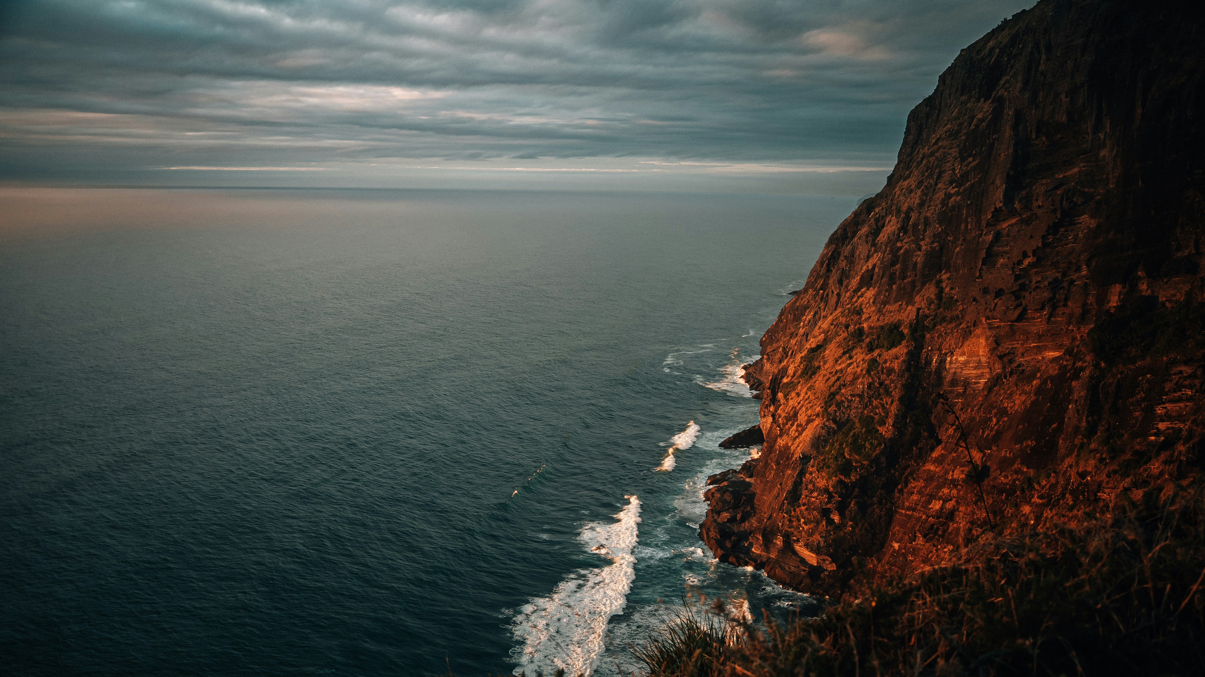 Cliffside Confluence: where sea meets rugged orange rock