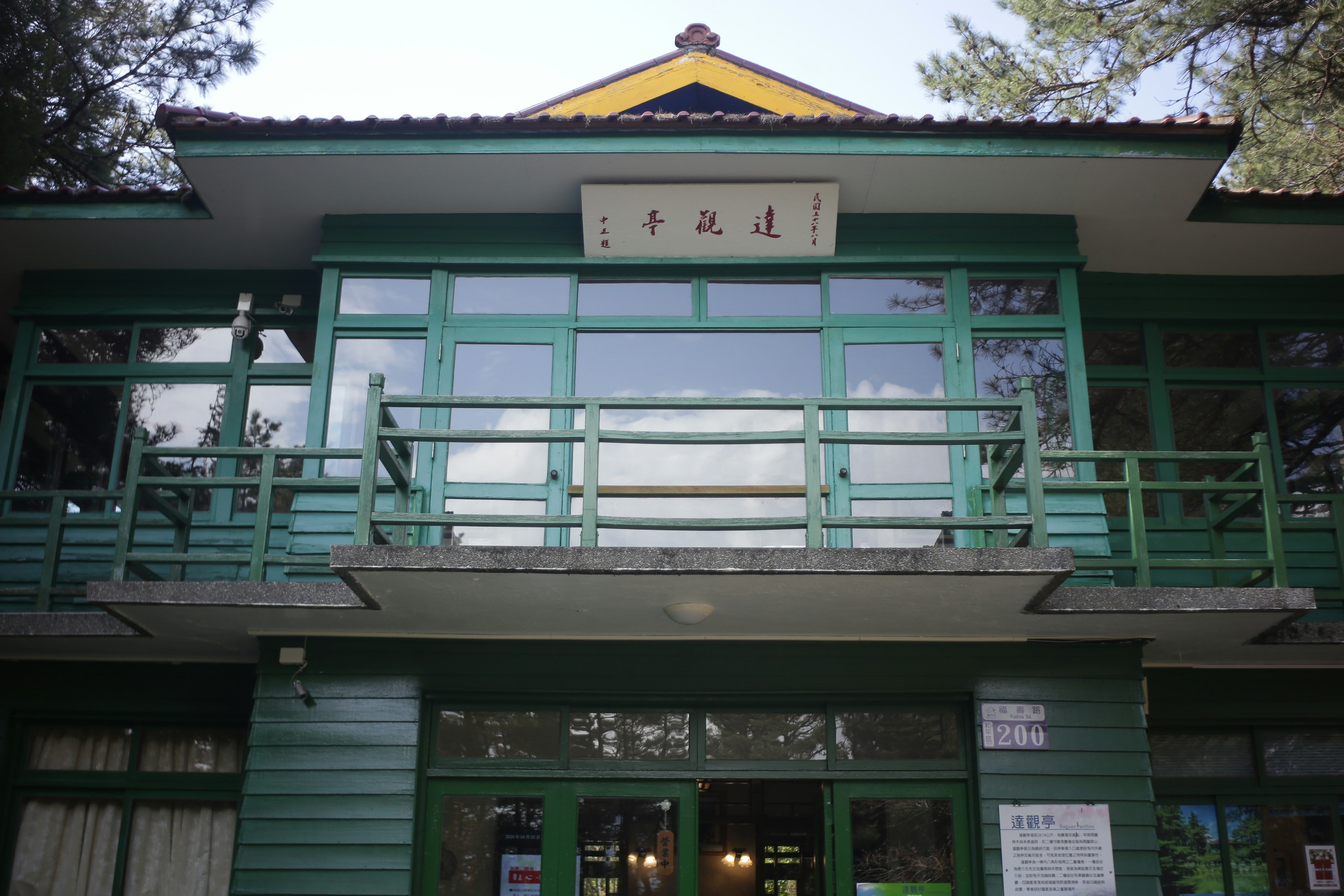 Mid-Century Facade of a Green-Tinted Building with Balcony