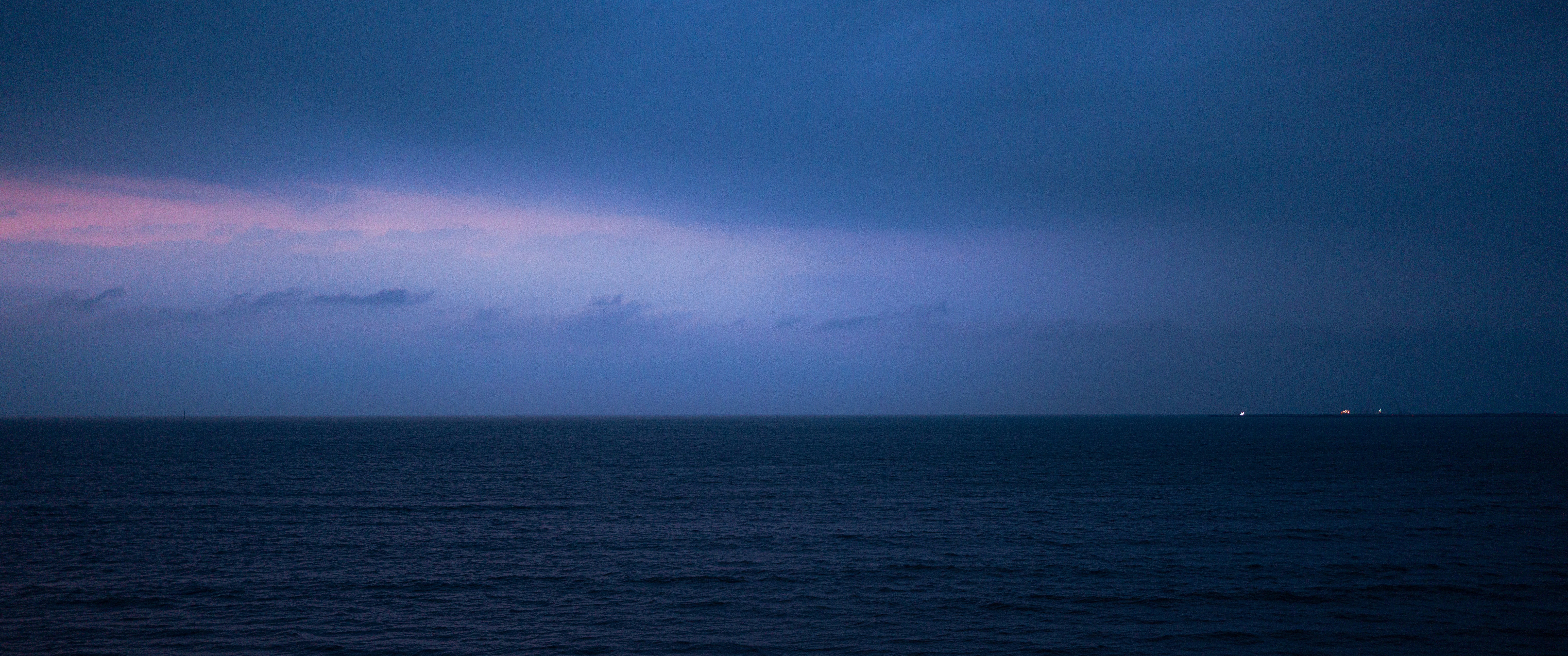 Distant horizon of dusk over a quiet sea