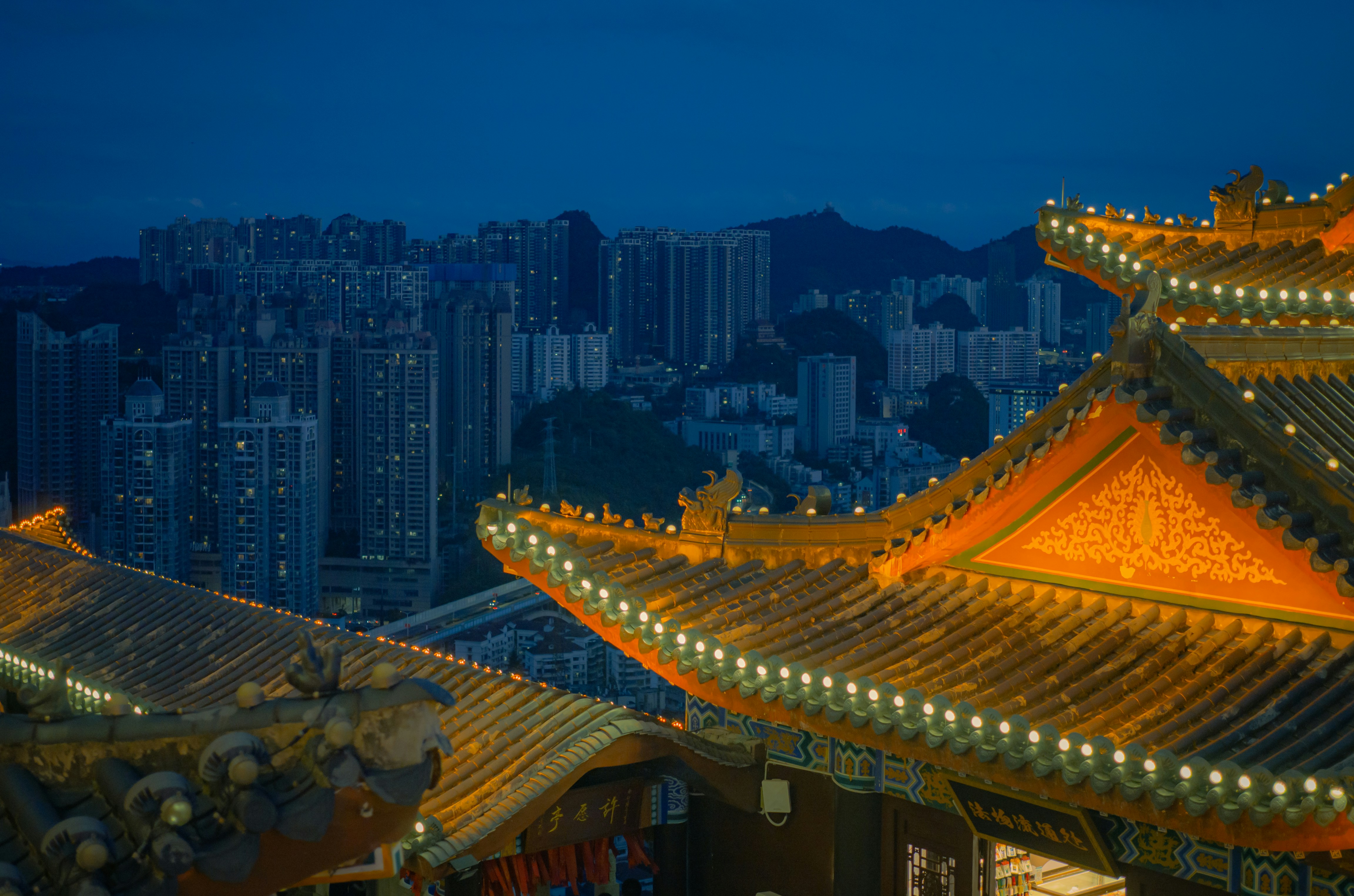 Lantern-lit Curves: A Temple Roof Framing a Distant Skyline