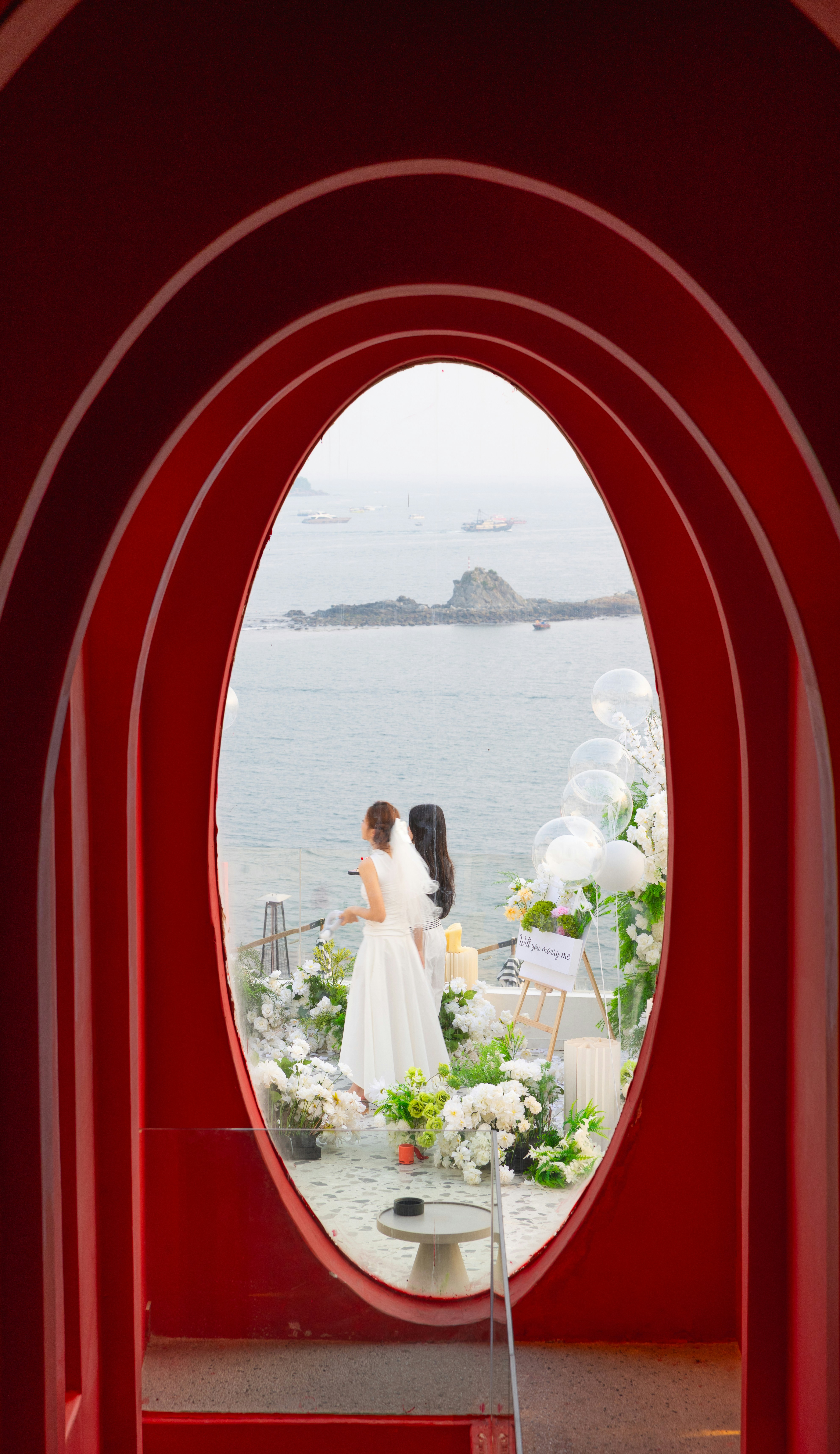 A Red Archway Framing an Overlook Wedding by the Sea