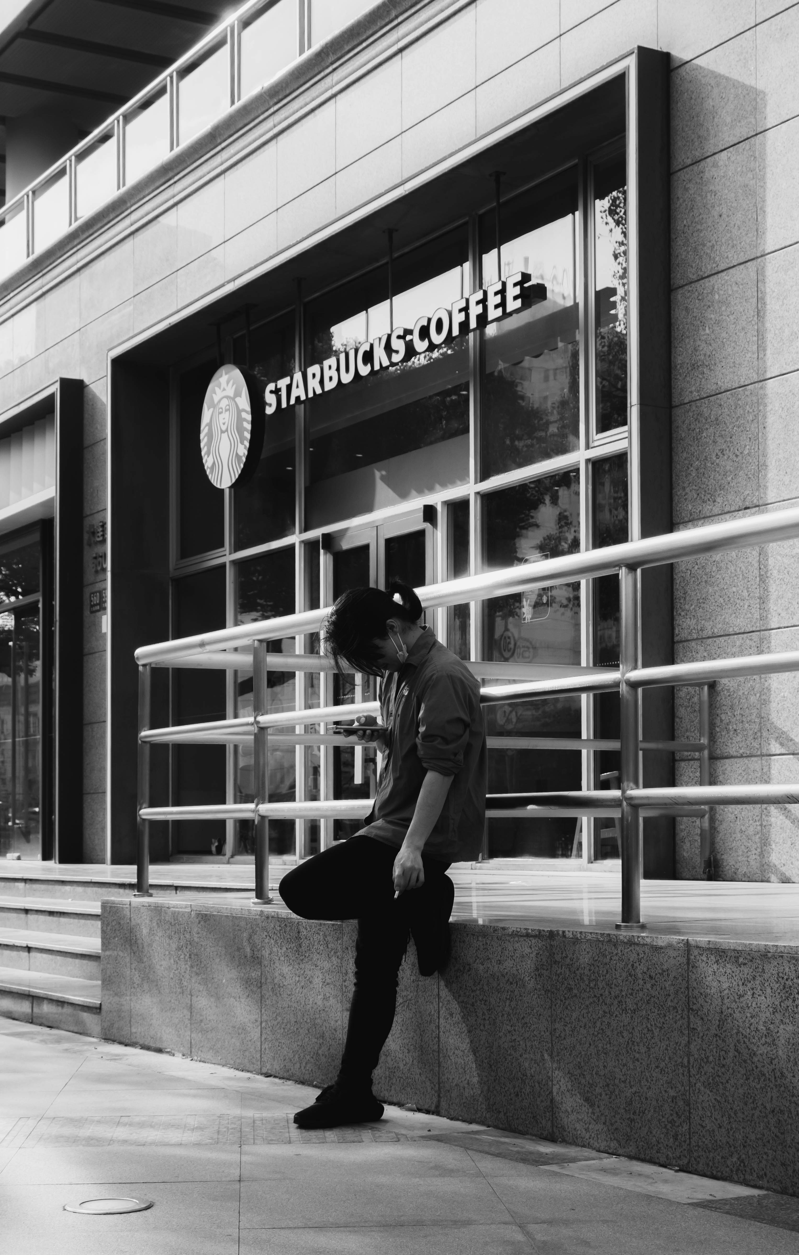 Quiet Pause Outside a Starbucks: A Portrait by the Rail