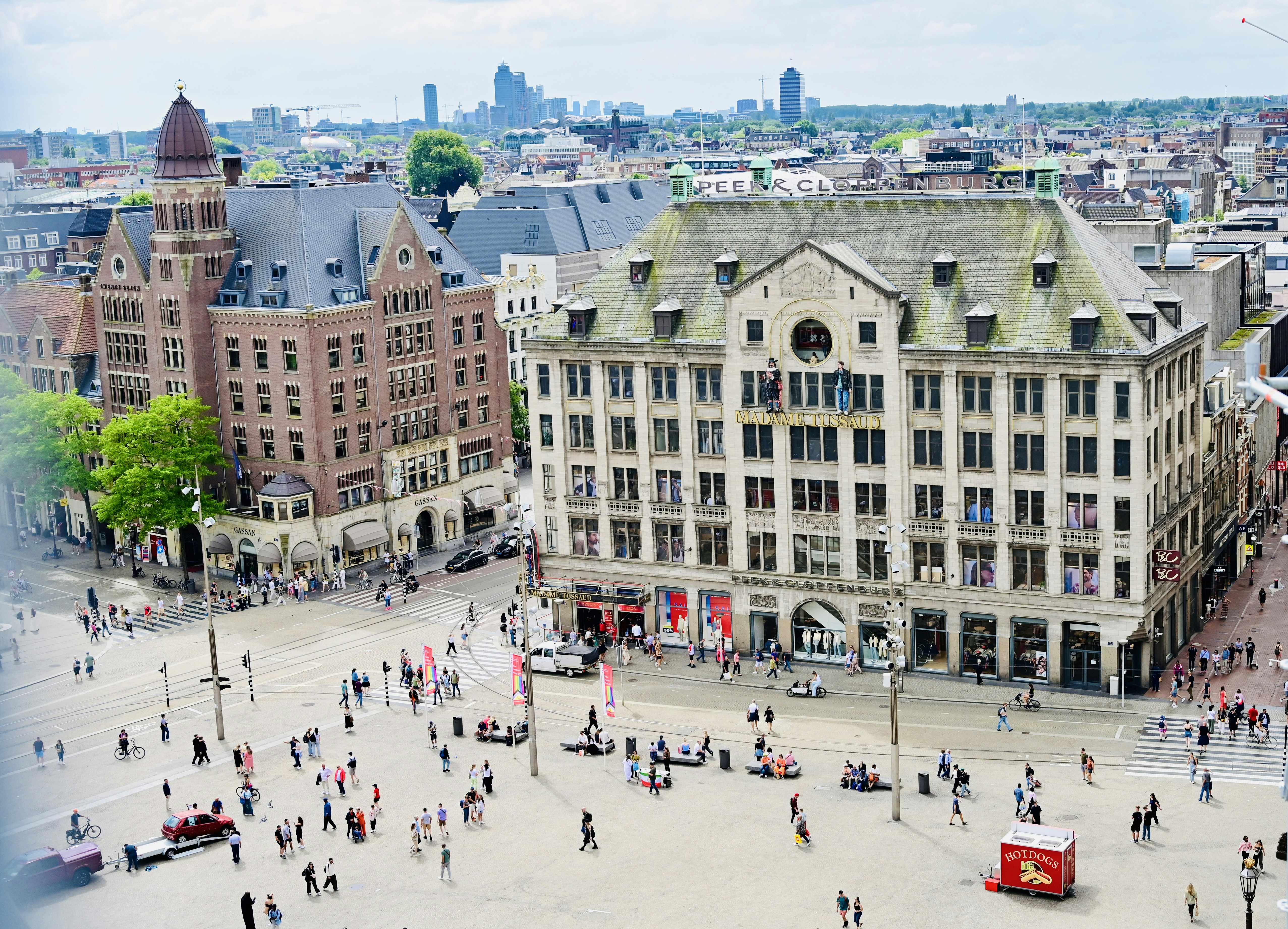 Bustling town square with historic buildings and shoppers in a European city center.
