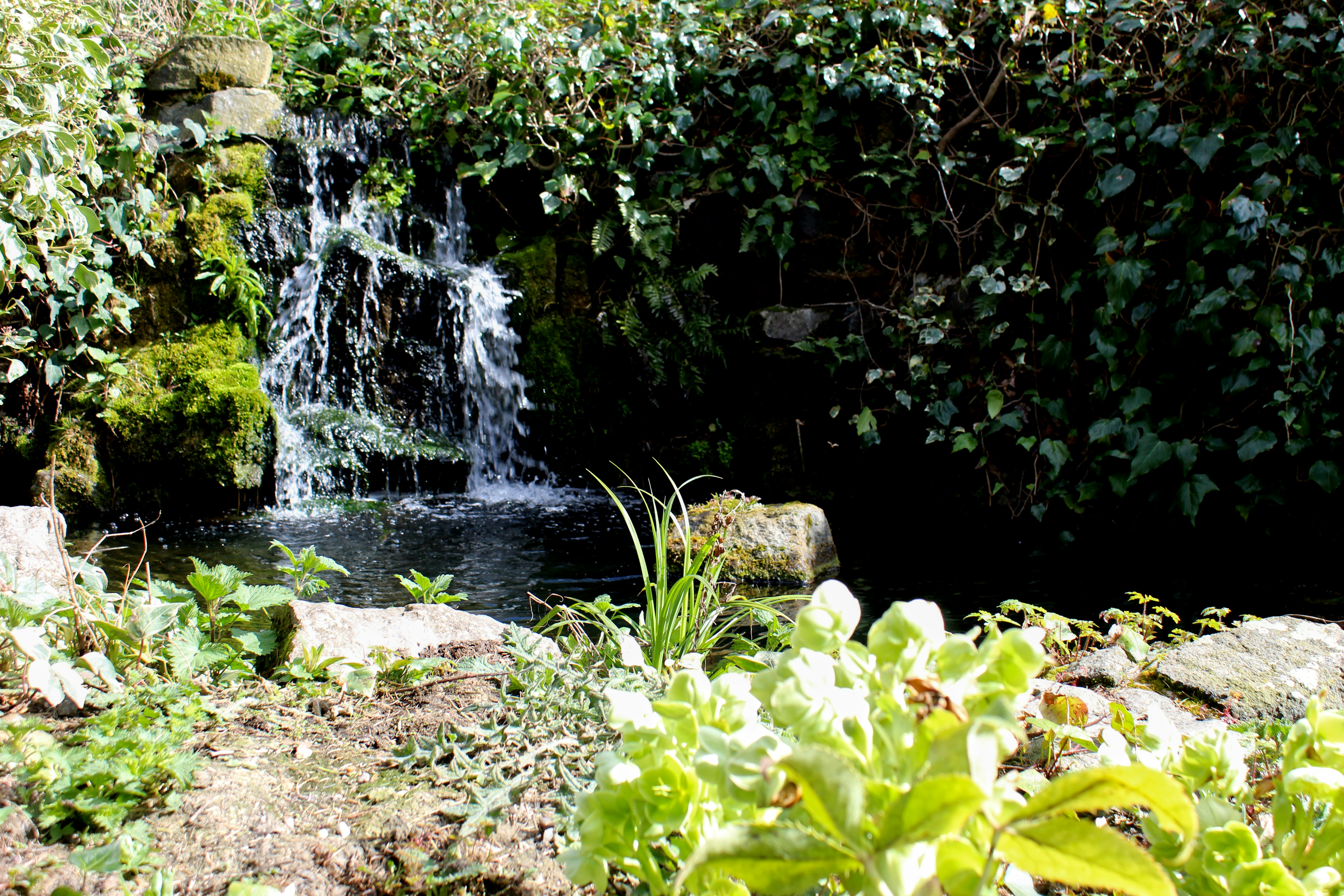 Sunlit Stones and Cascading Water in a Quiet Garden