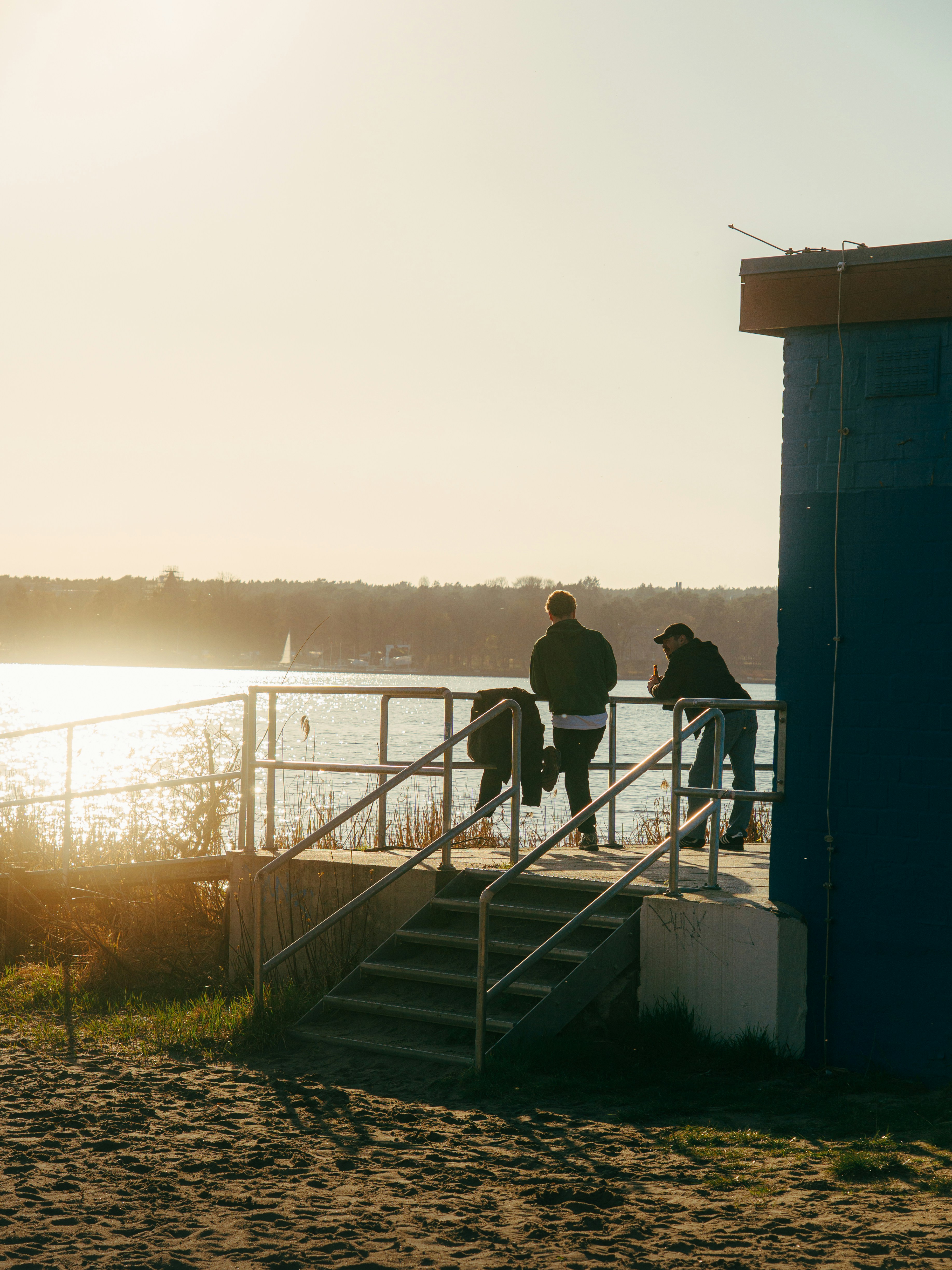 Sunlit Figures on the Pier: Quiet Interaction by the Water