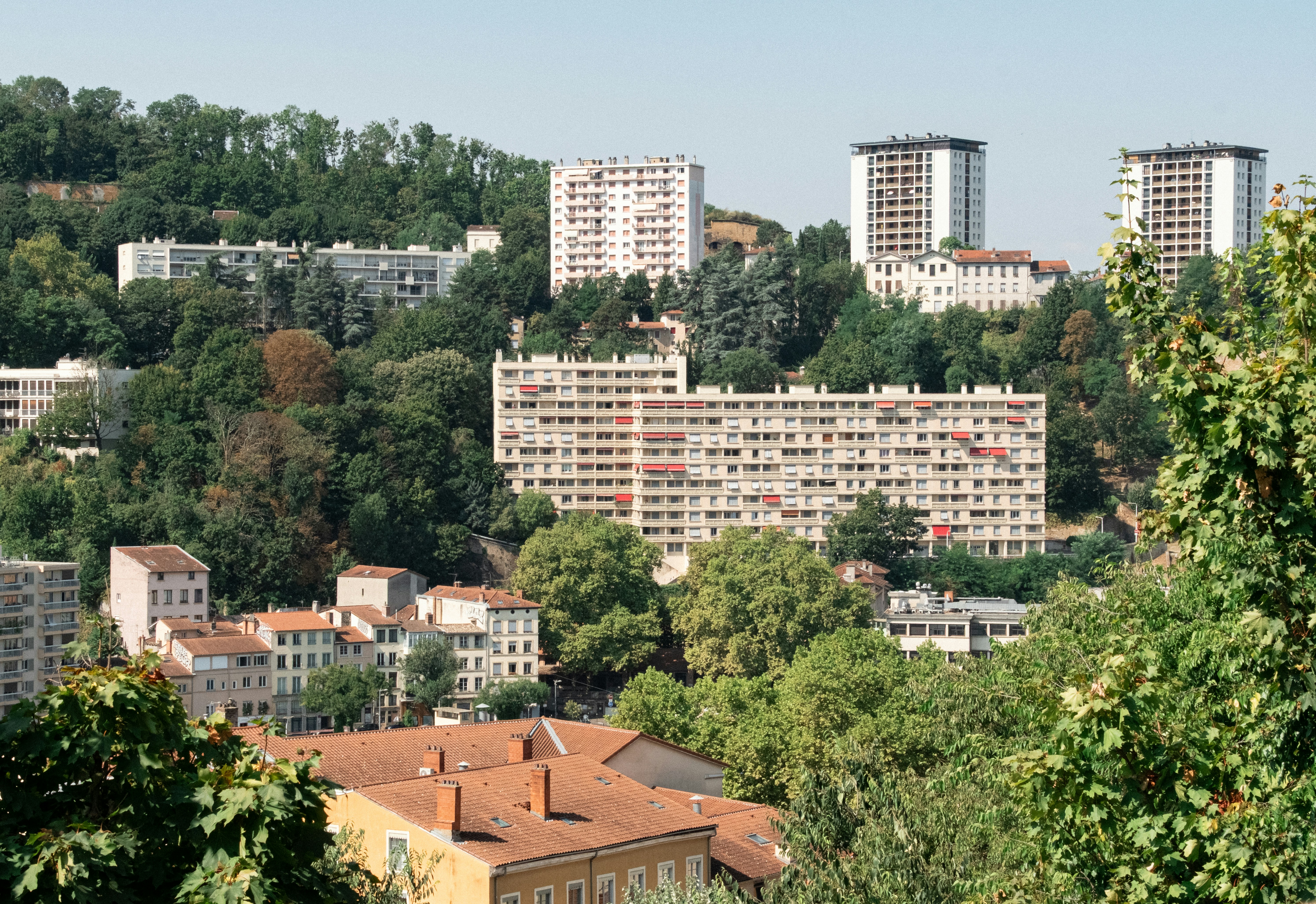 Hillside Cityscape: Concrete Blocks Amid Verdant Ridges