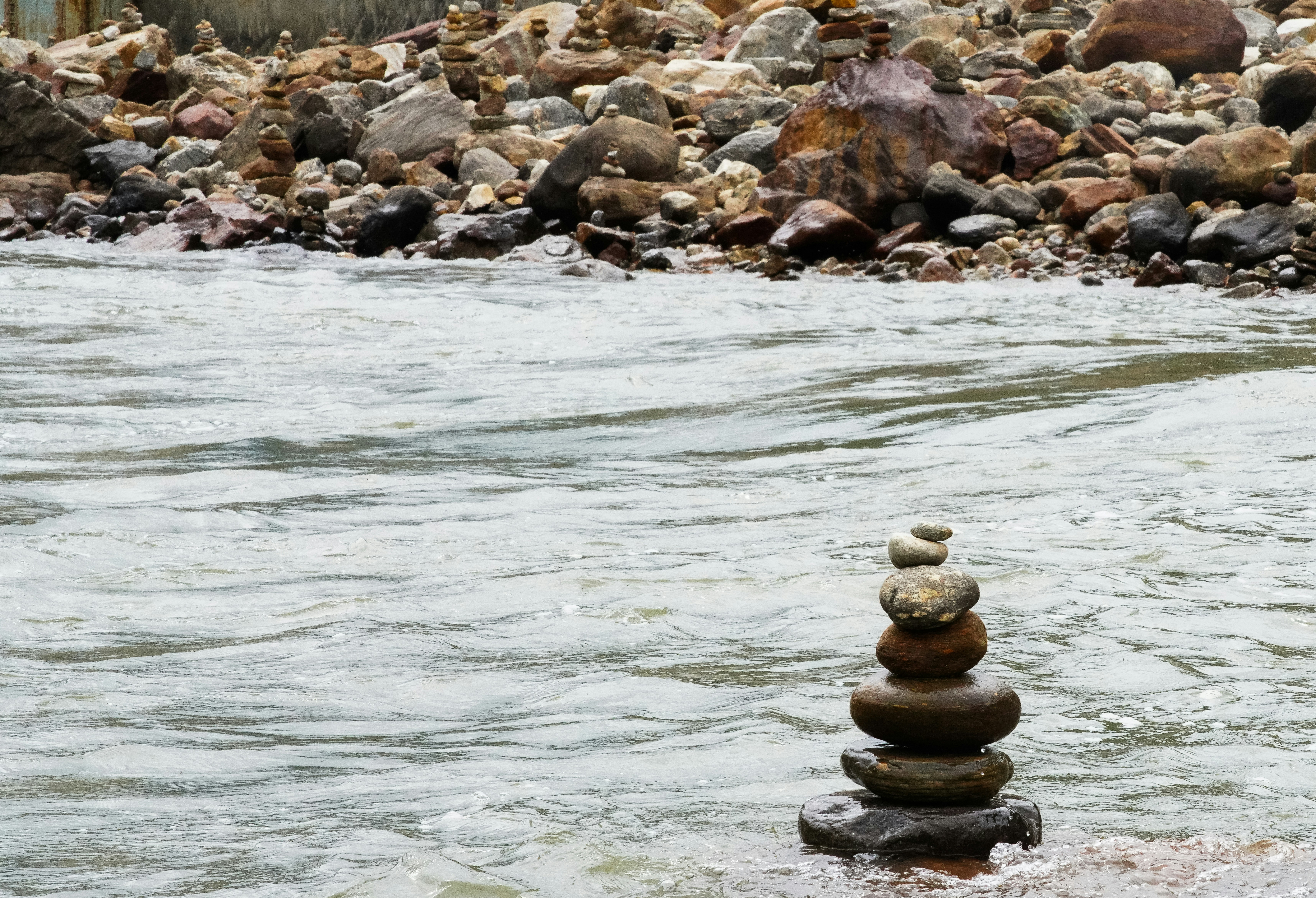 Stacked stones by a rippling shoreline