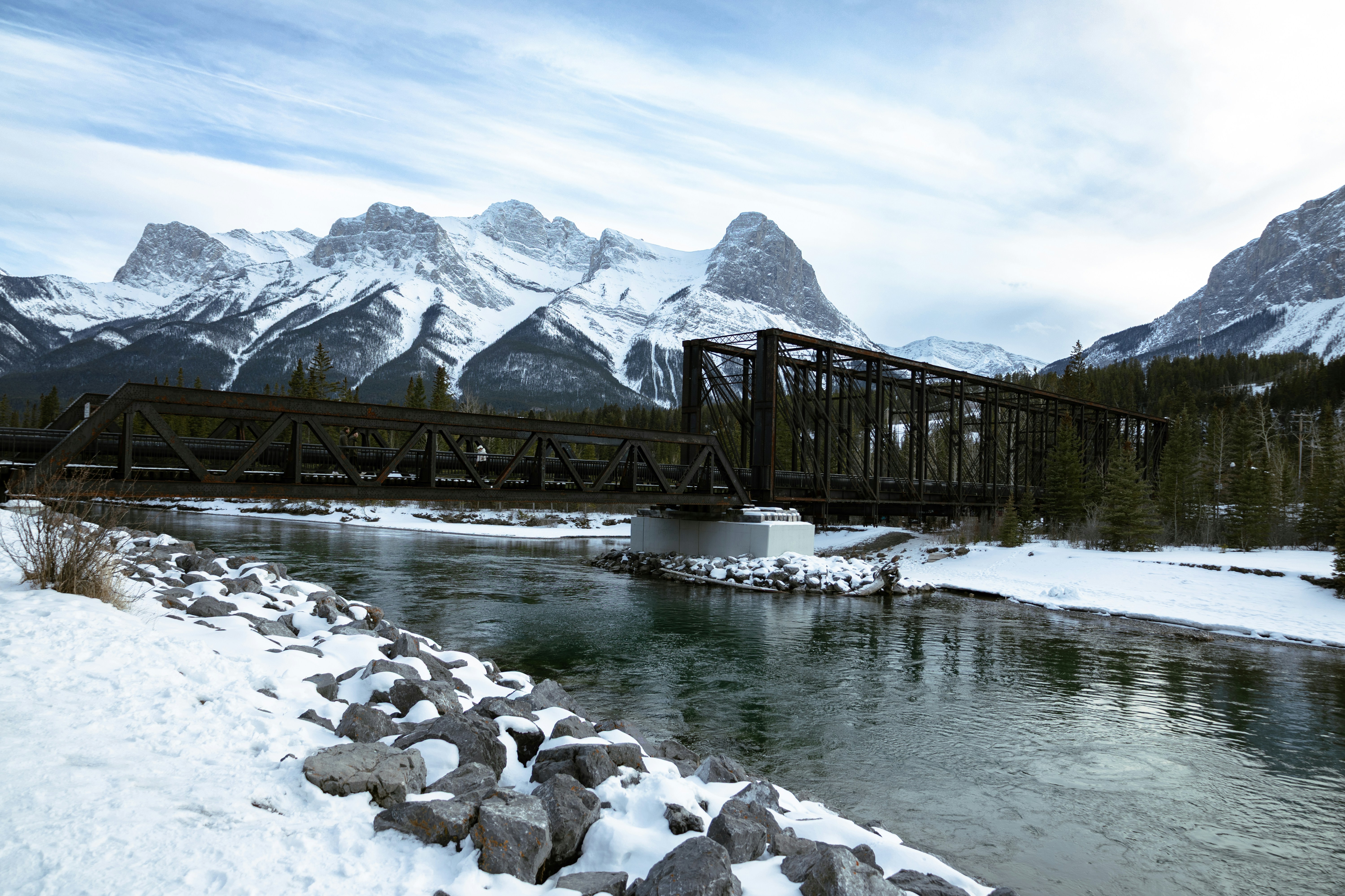 Snow-Capped Peaks and Timber Bridge Across a Quiet River
