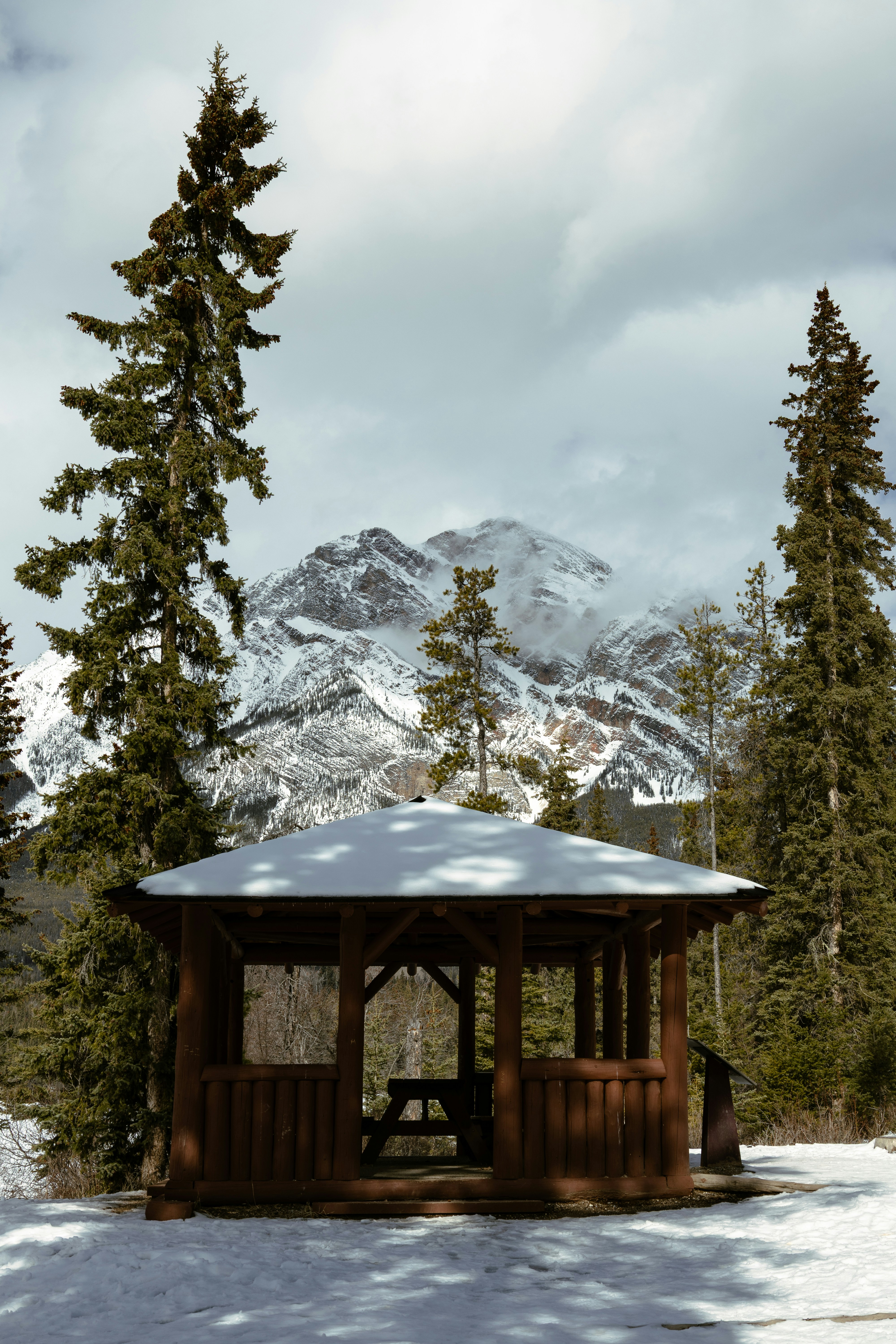 Snowy Peaks Framed by a Rustic Shelter
