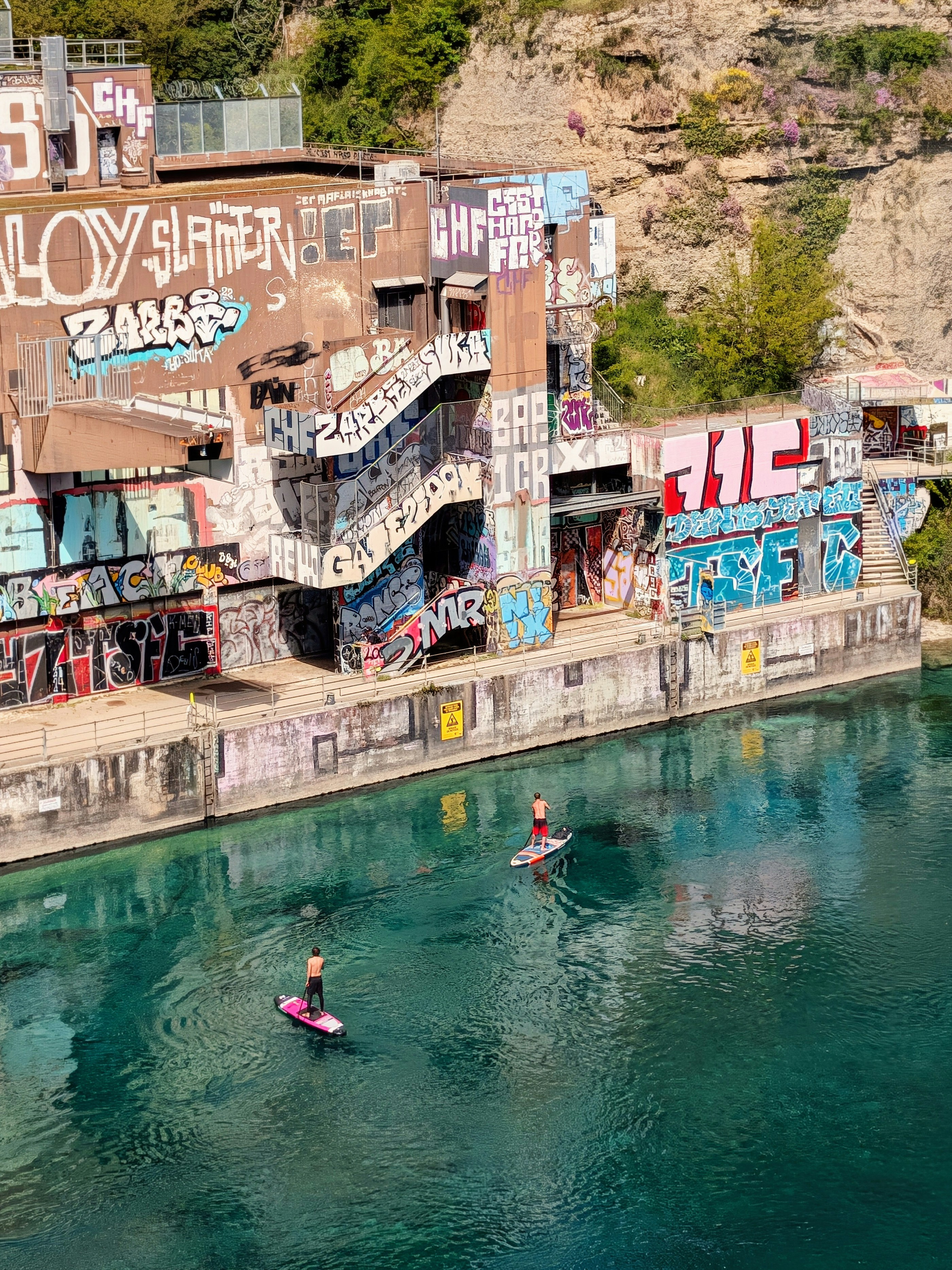Graffiti-clad Quarry Waterfront with Stand-up Paddlers