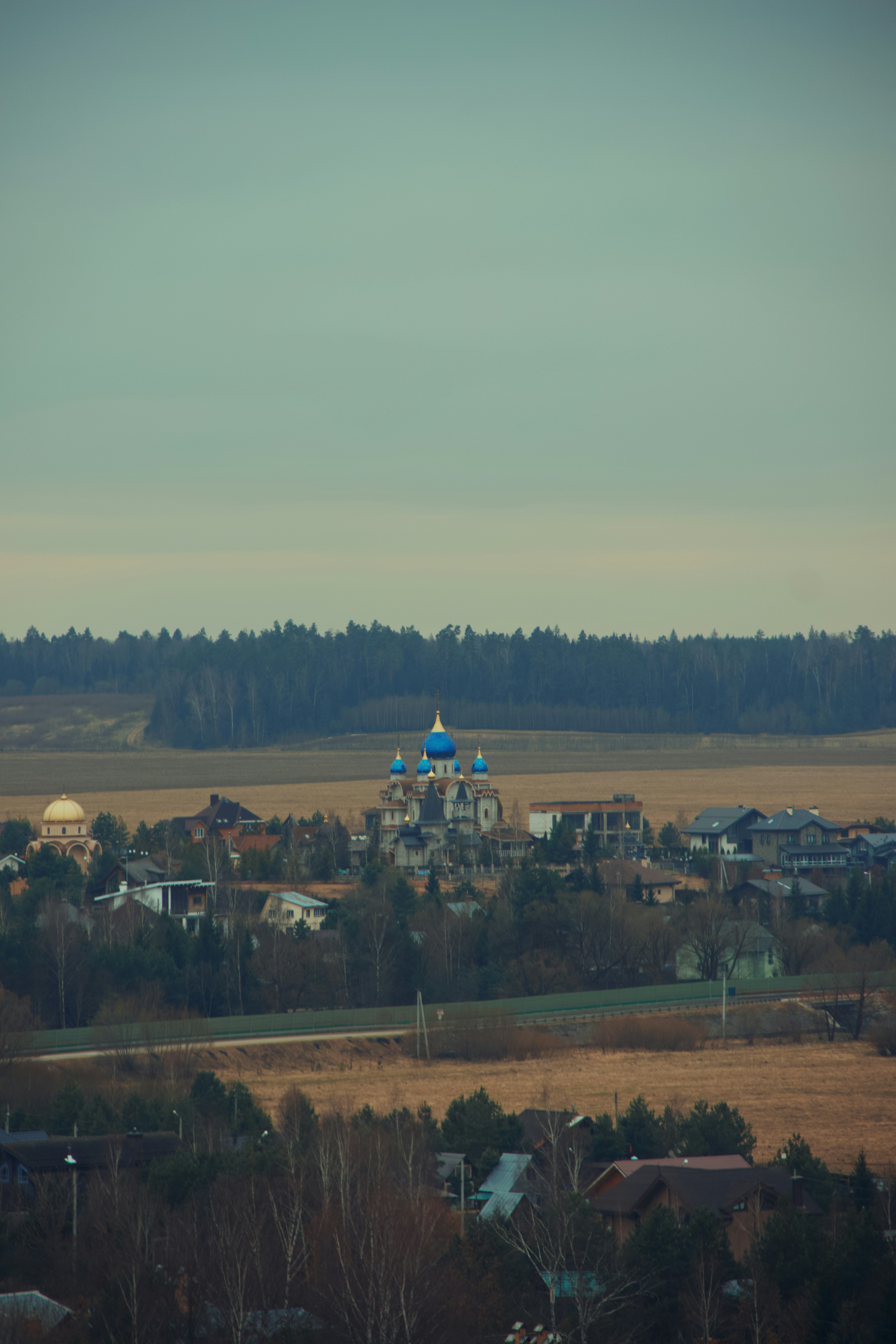 Blue-domed church rising above a quiet village horizon