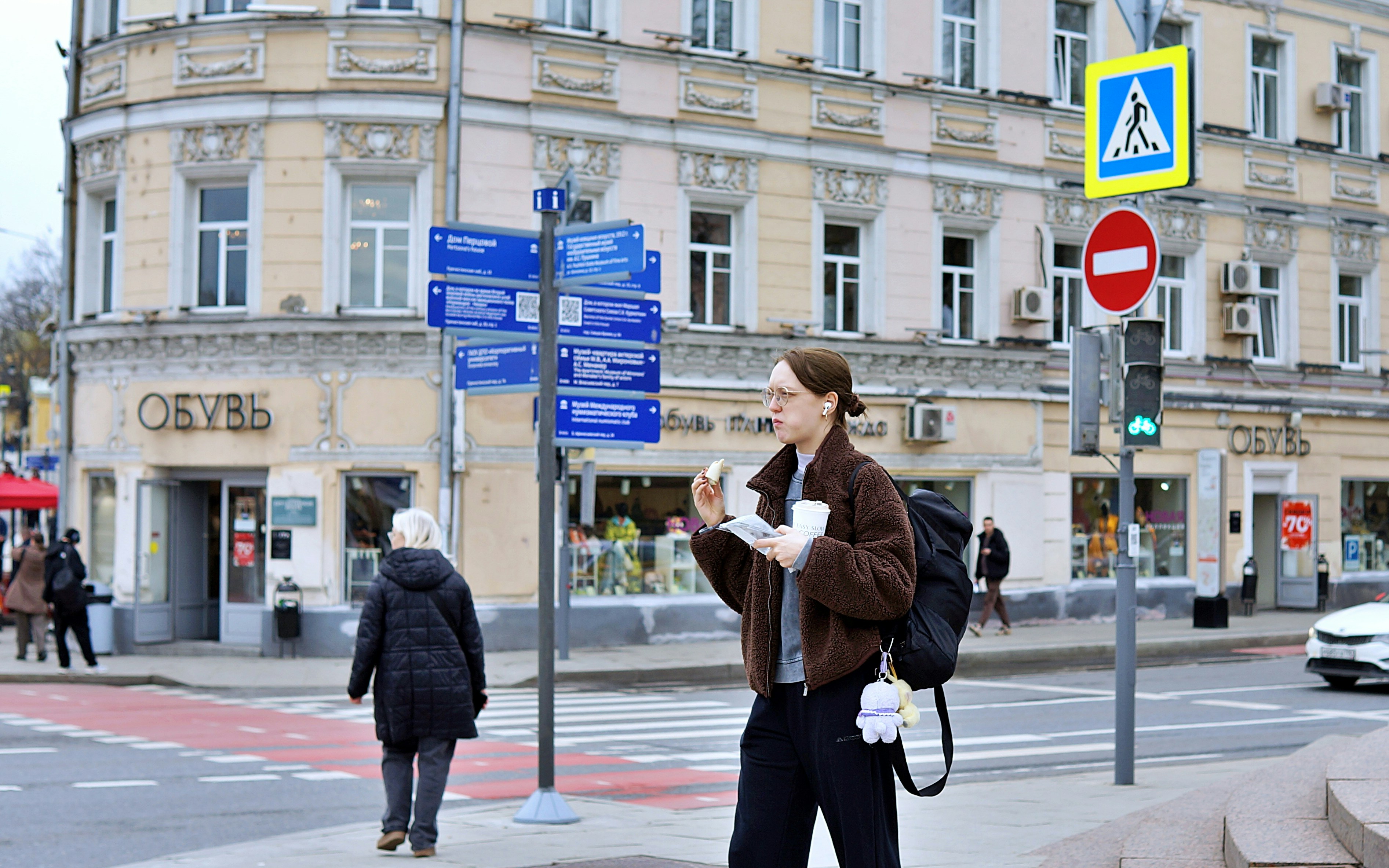 Pedestrian Crossing and City Life near the Blue Sign