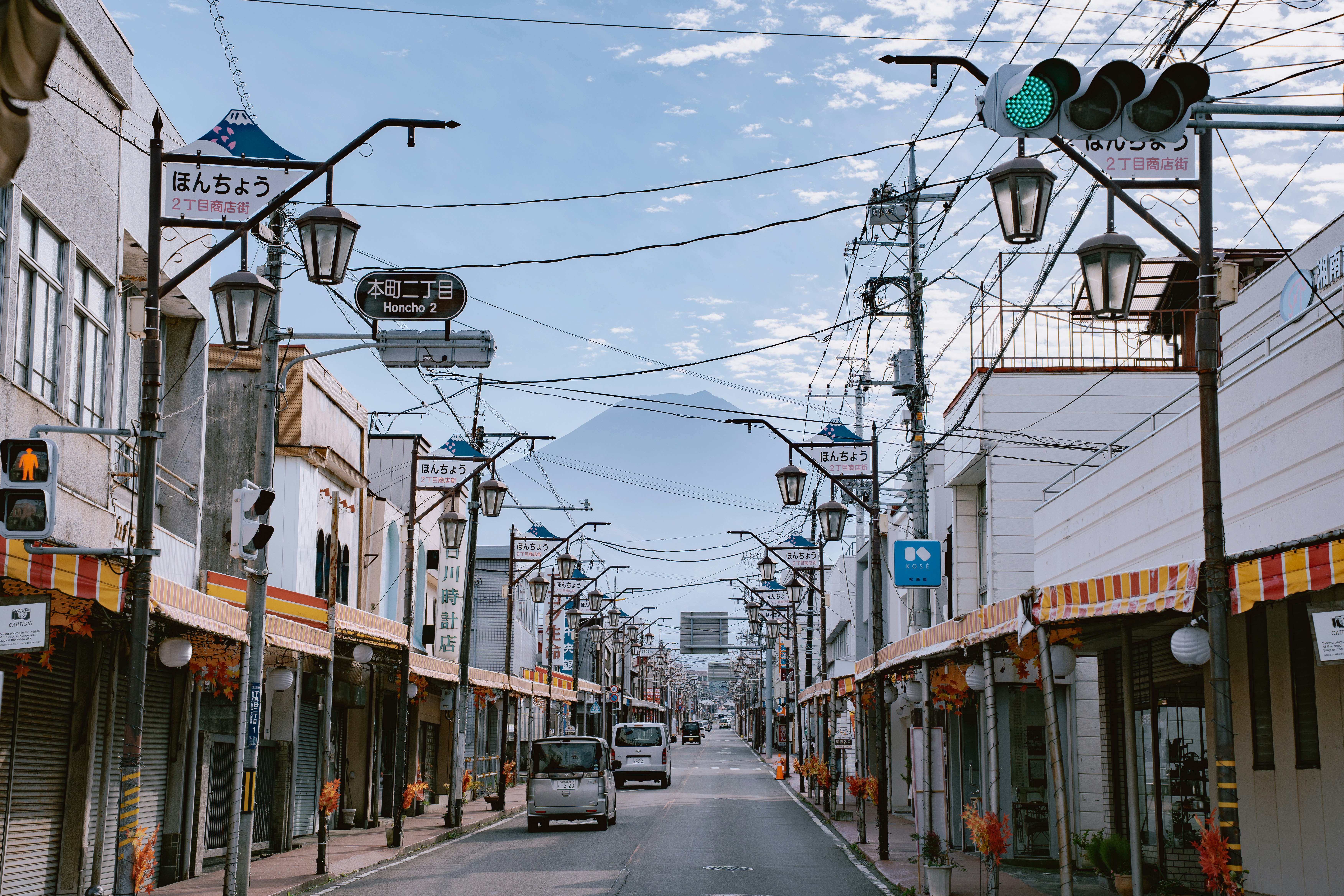 Sunlit Main Street with Vintage Lanterns and Mountain Backdrop