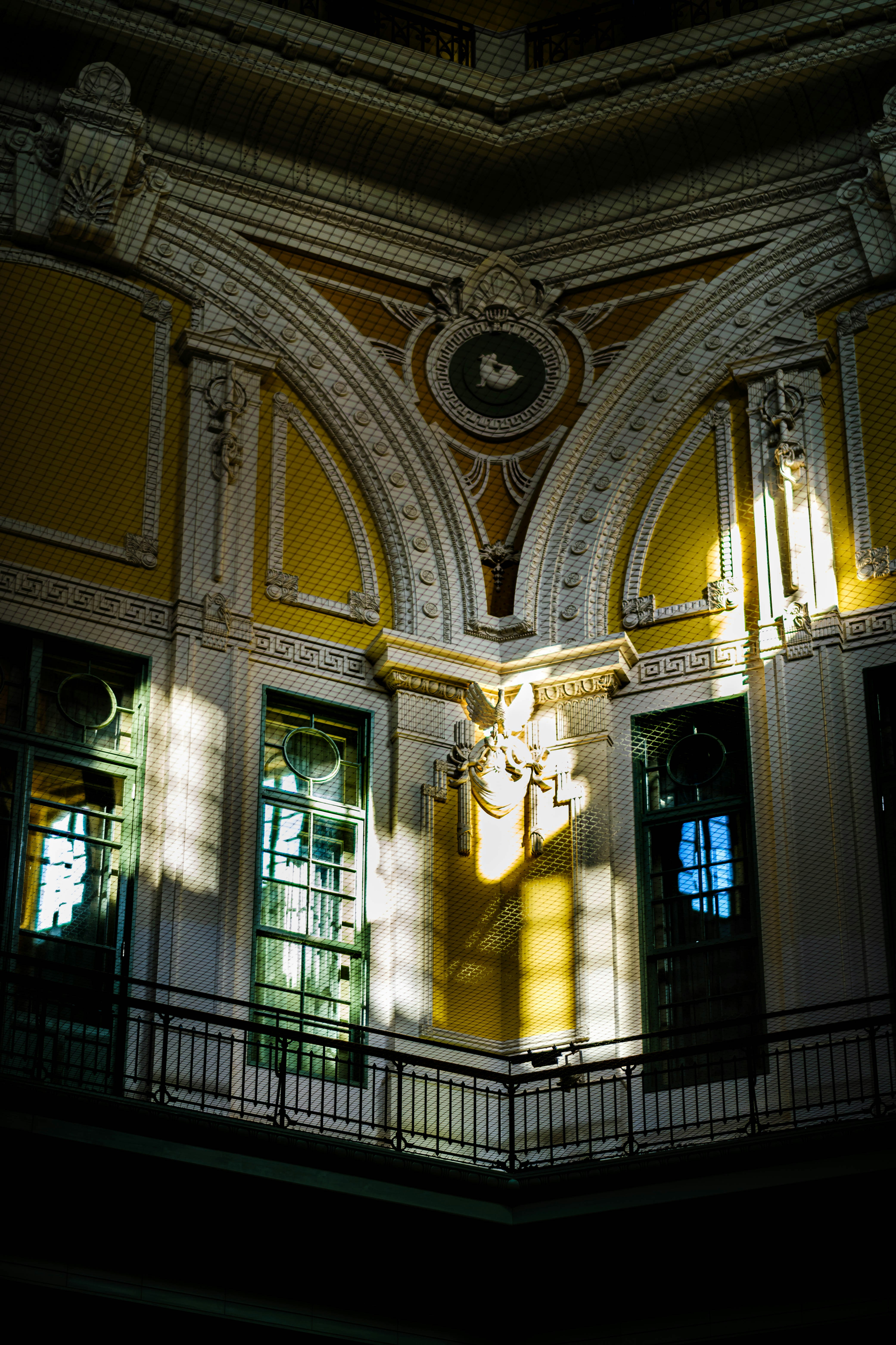 Golden Archways and Shadowed Facade in a Dimly Lit Atrium