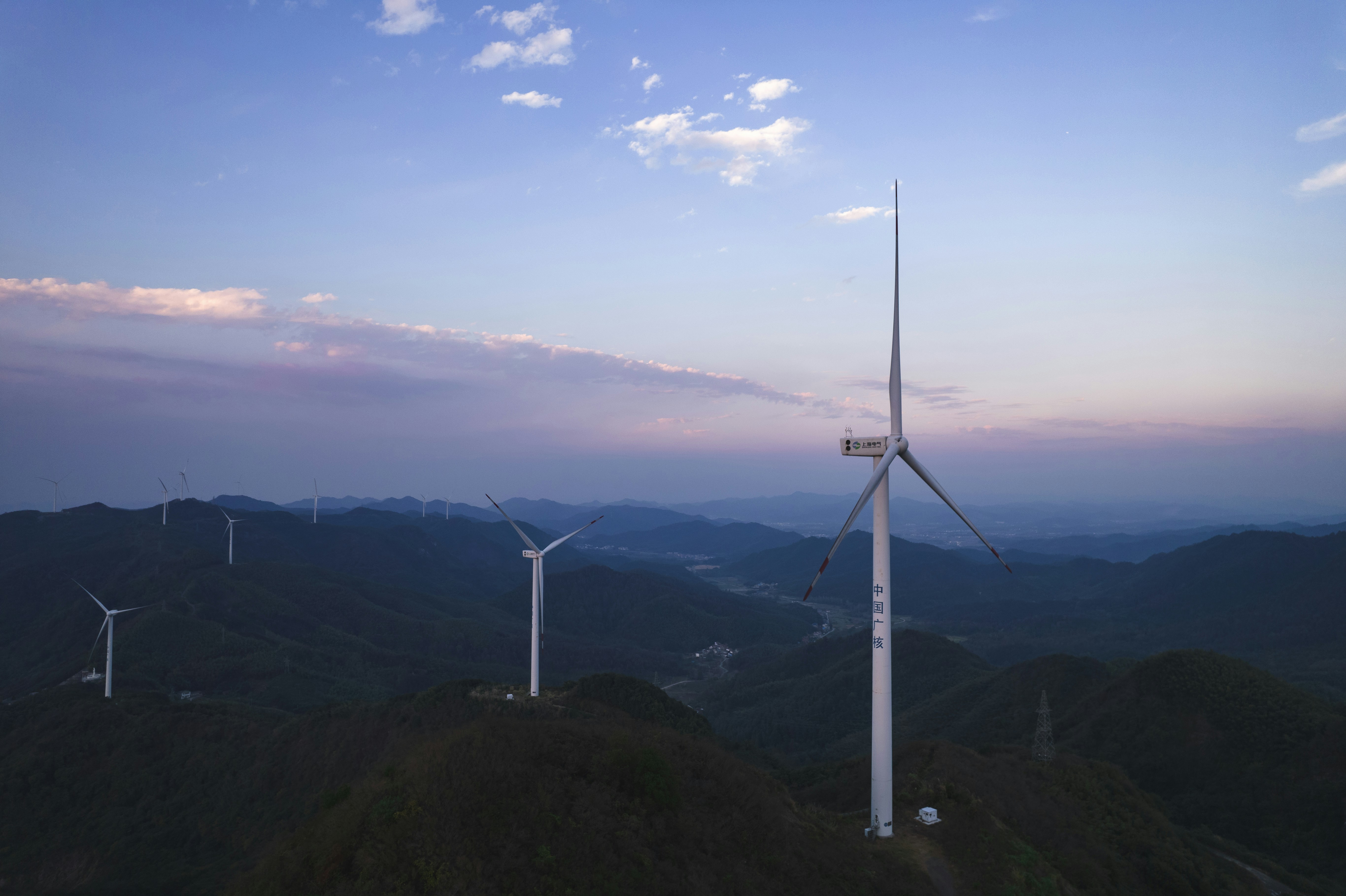 Whispering Giants: Wind Turbines Crown the Dusk-Draped Ridge