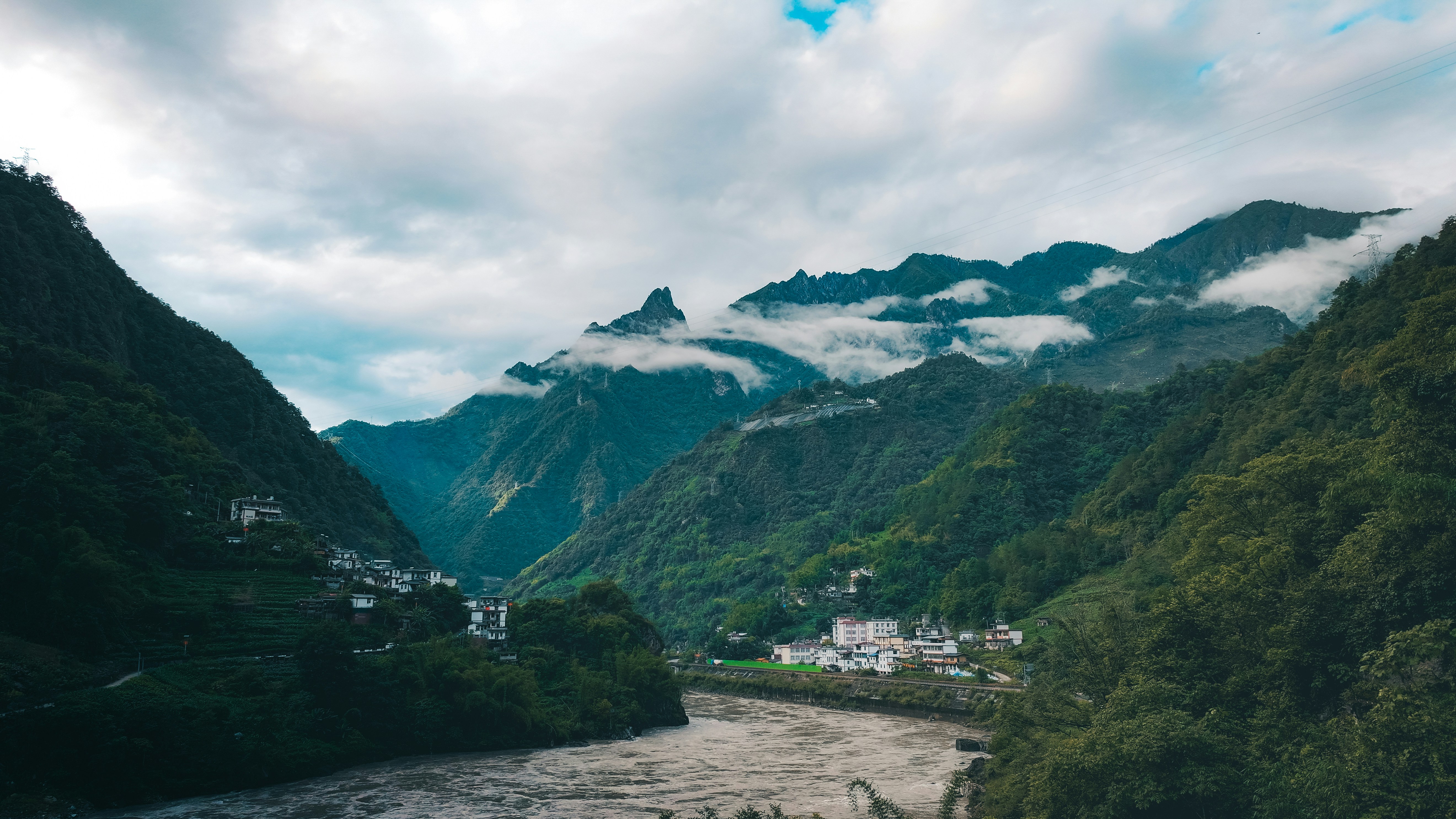 River valley village framed by misty karst peaks