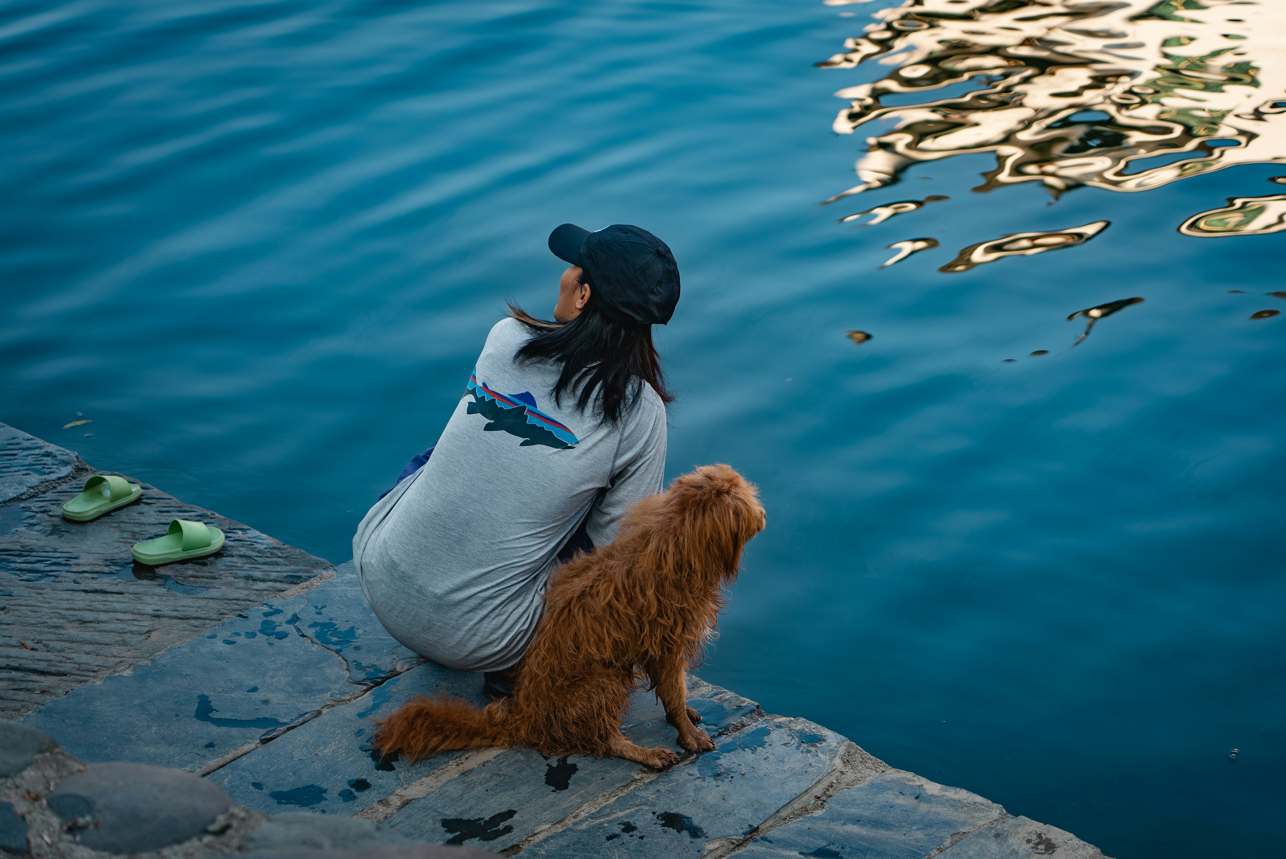 Dockside Contemplation: A Woman and a Dog at Calm Waters