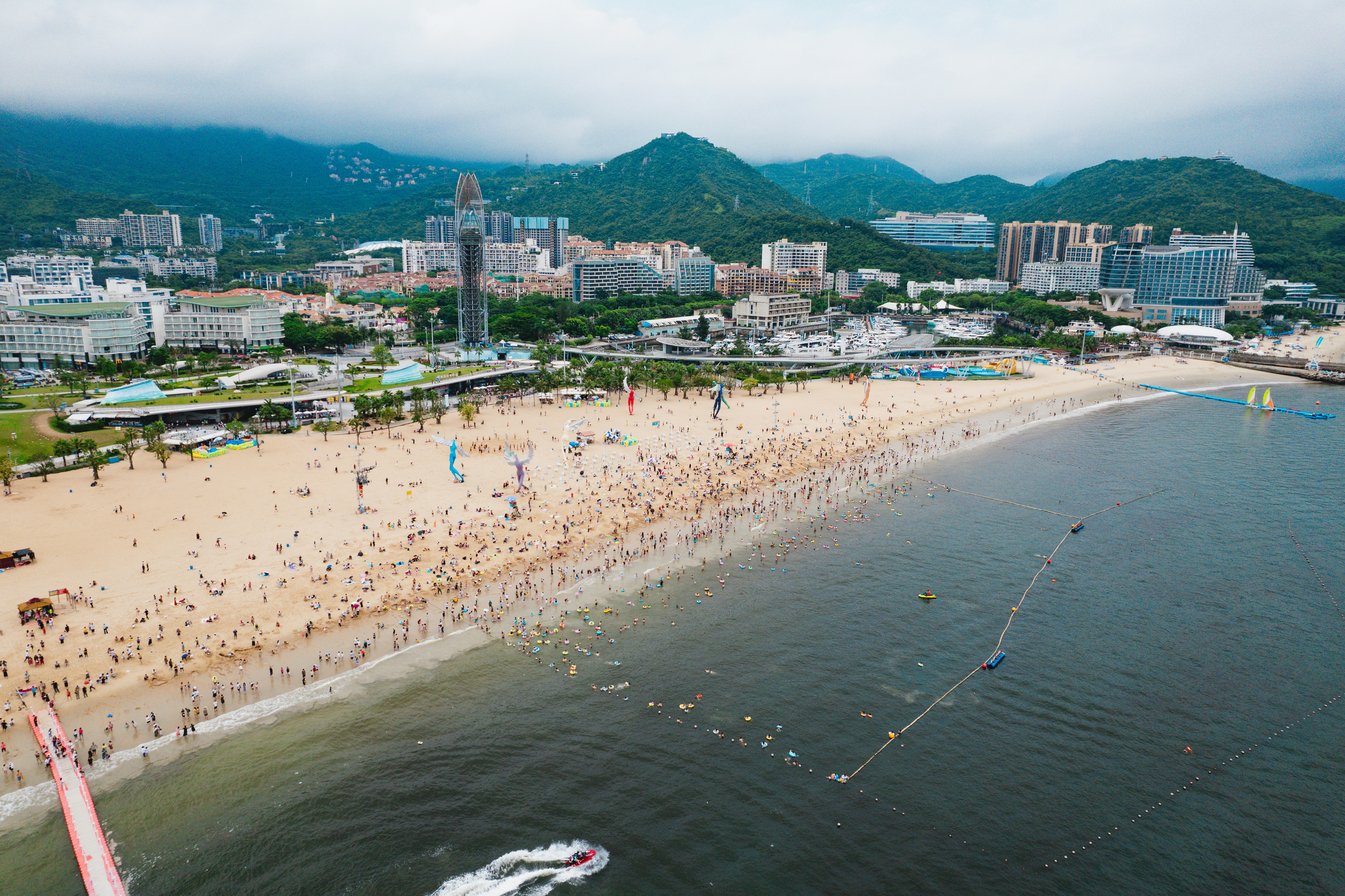 Aerial Beachfront: Sunlit Shoreline and Coastal Cityscape
