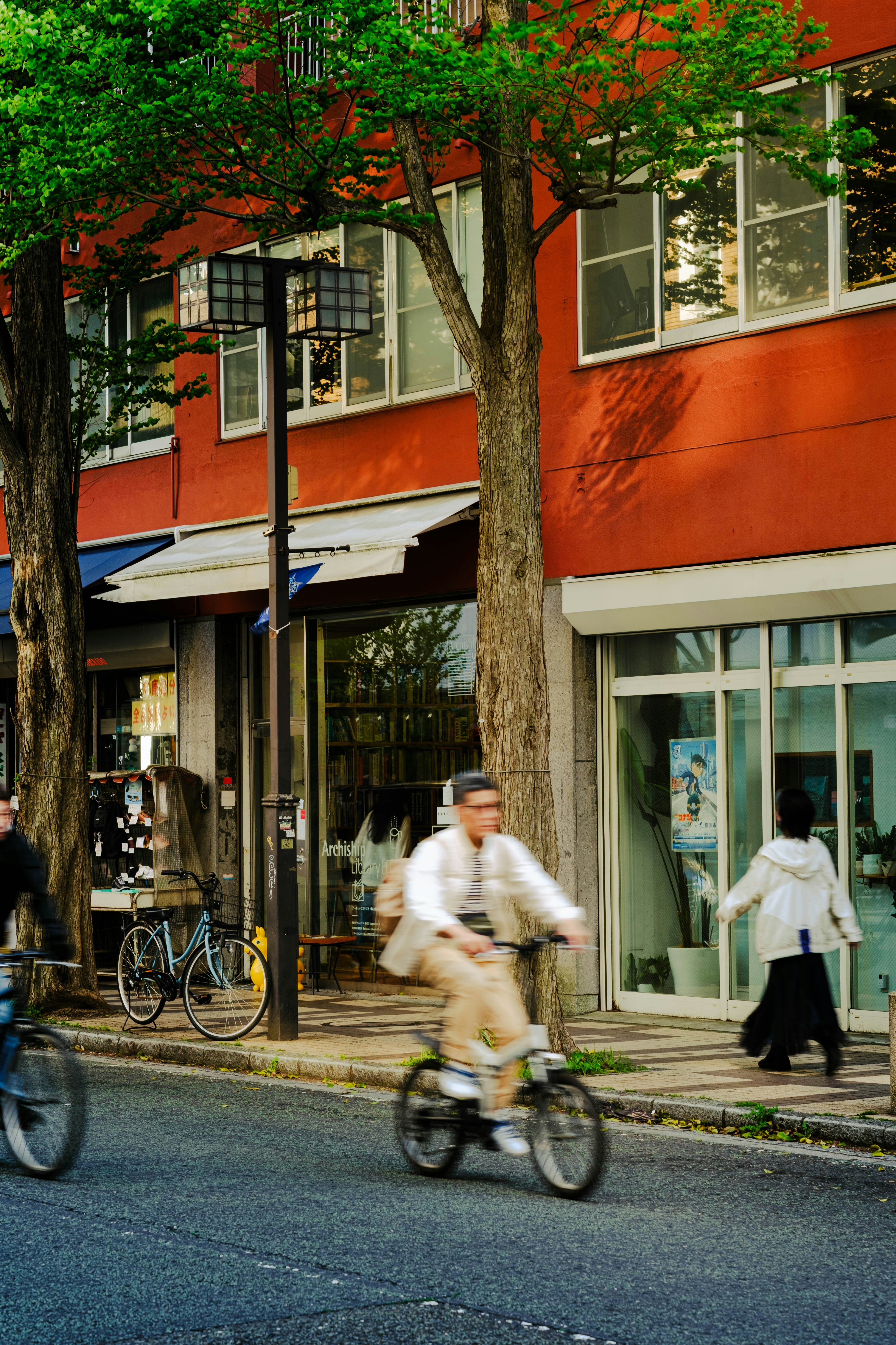 Street in Motion: Blurred Cyclist in Front of a Red Building
