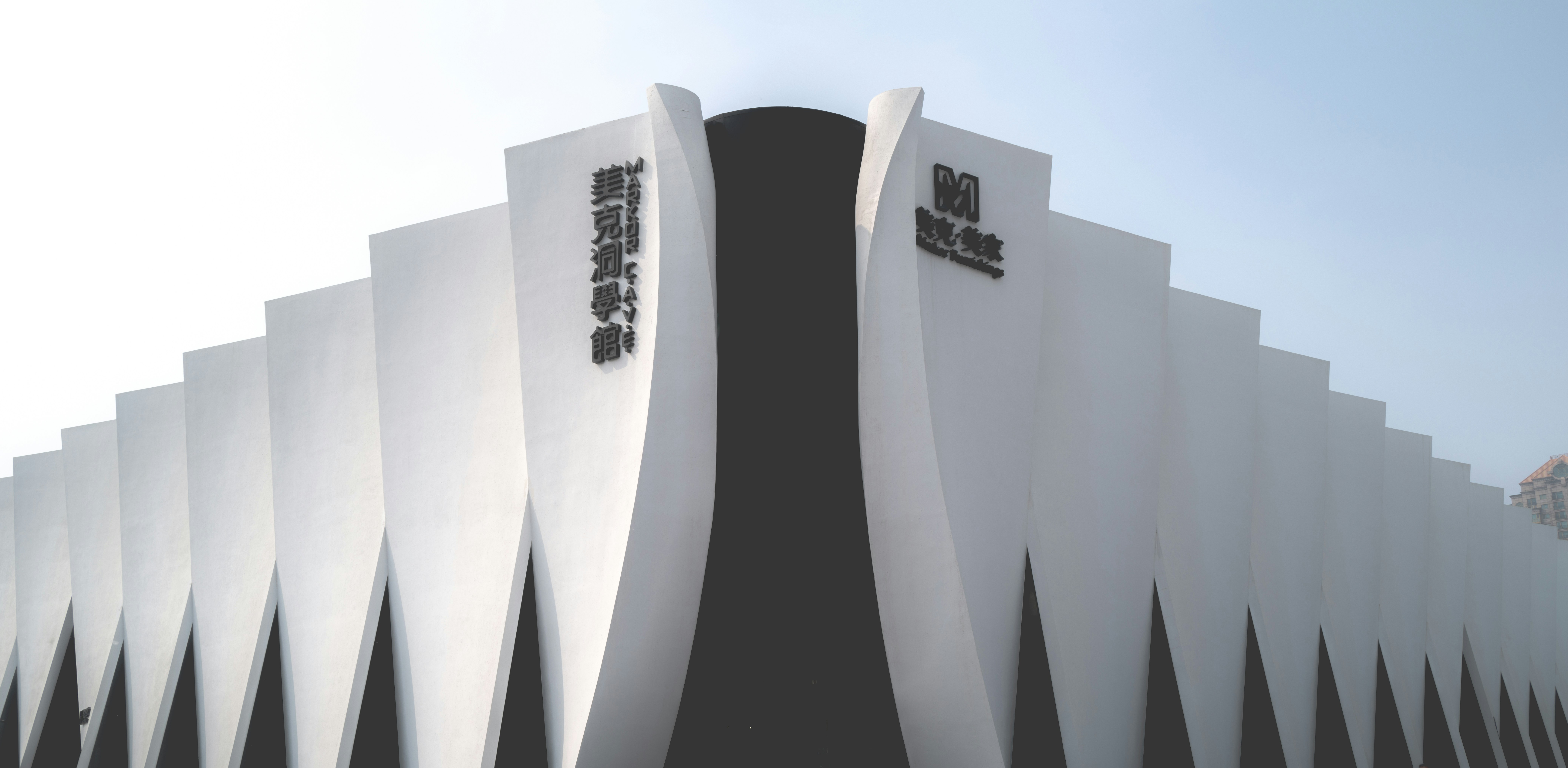 White architectural fins converge into a dramatic central arch