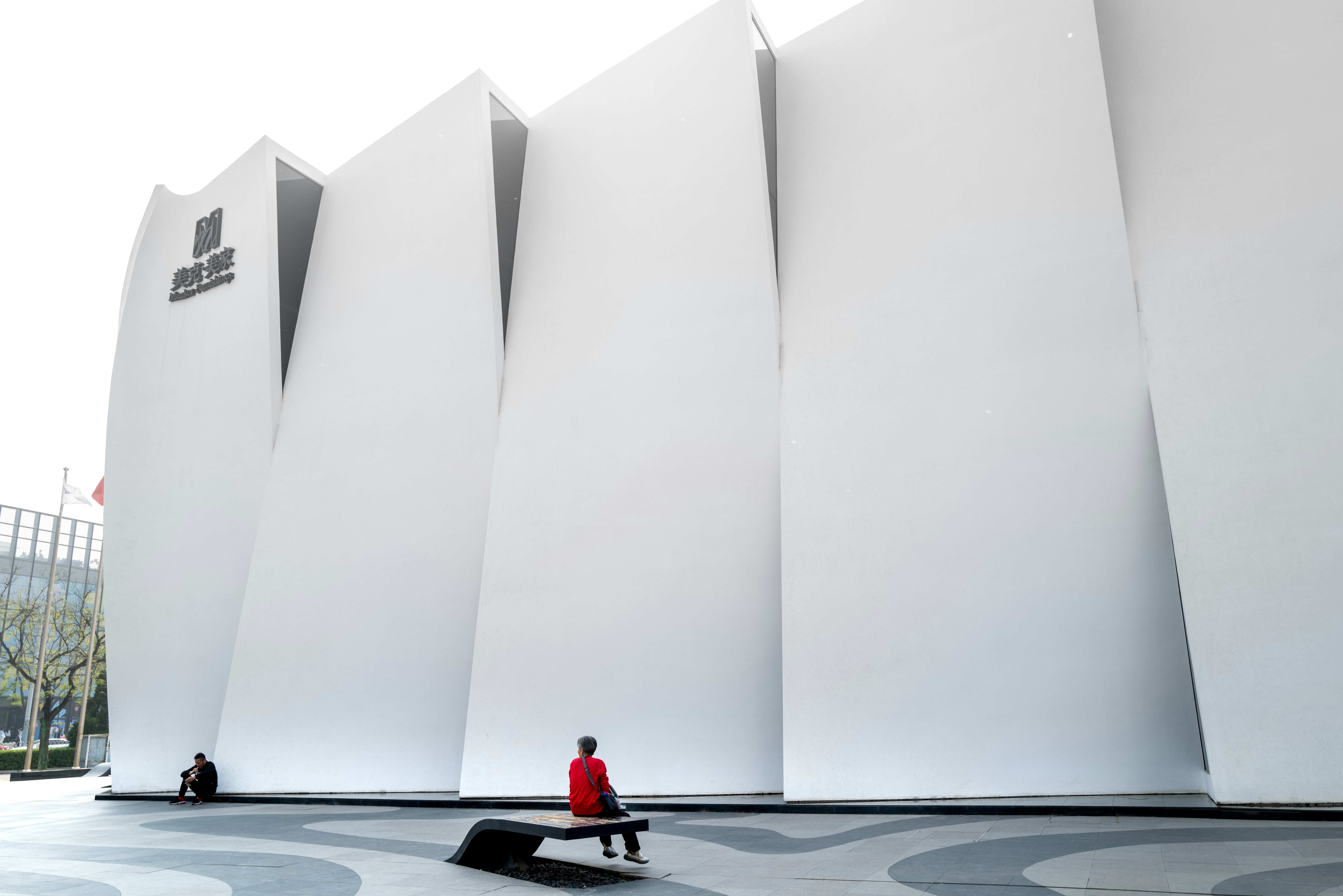 Red-clad skater at the base of sculptural white arches