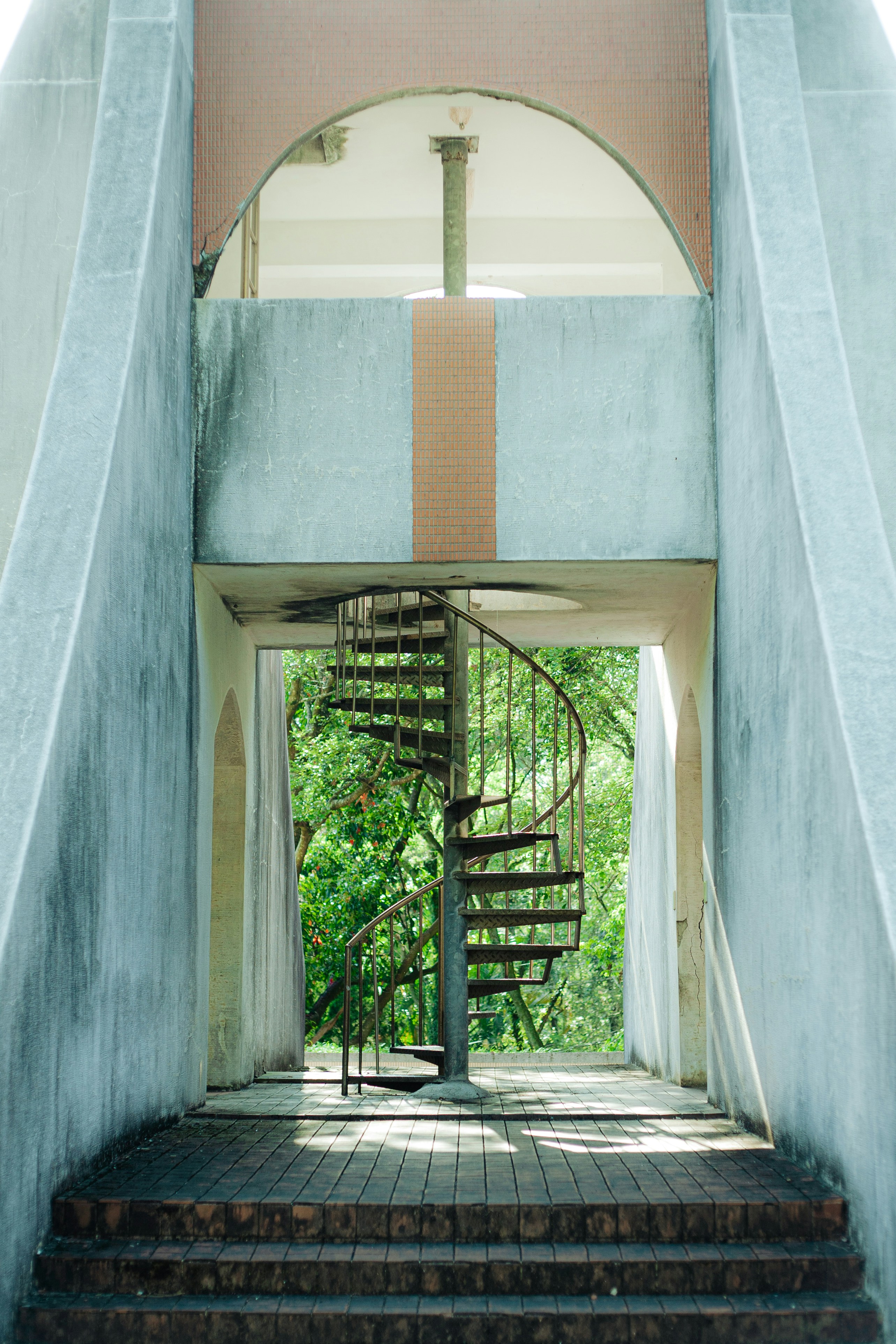 Spiral Staircase Framed by Concrete Arcways
