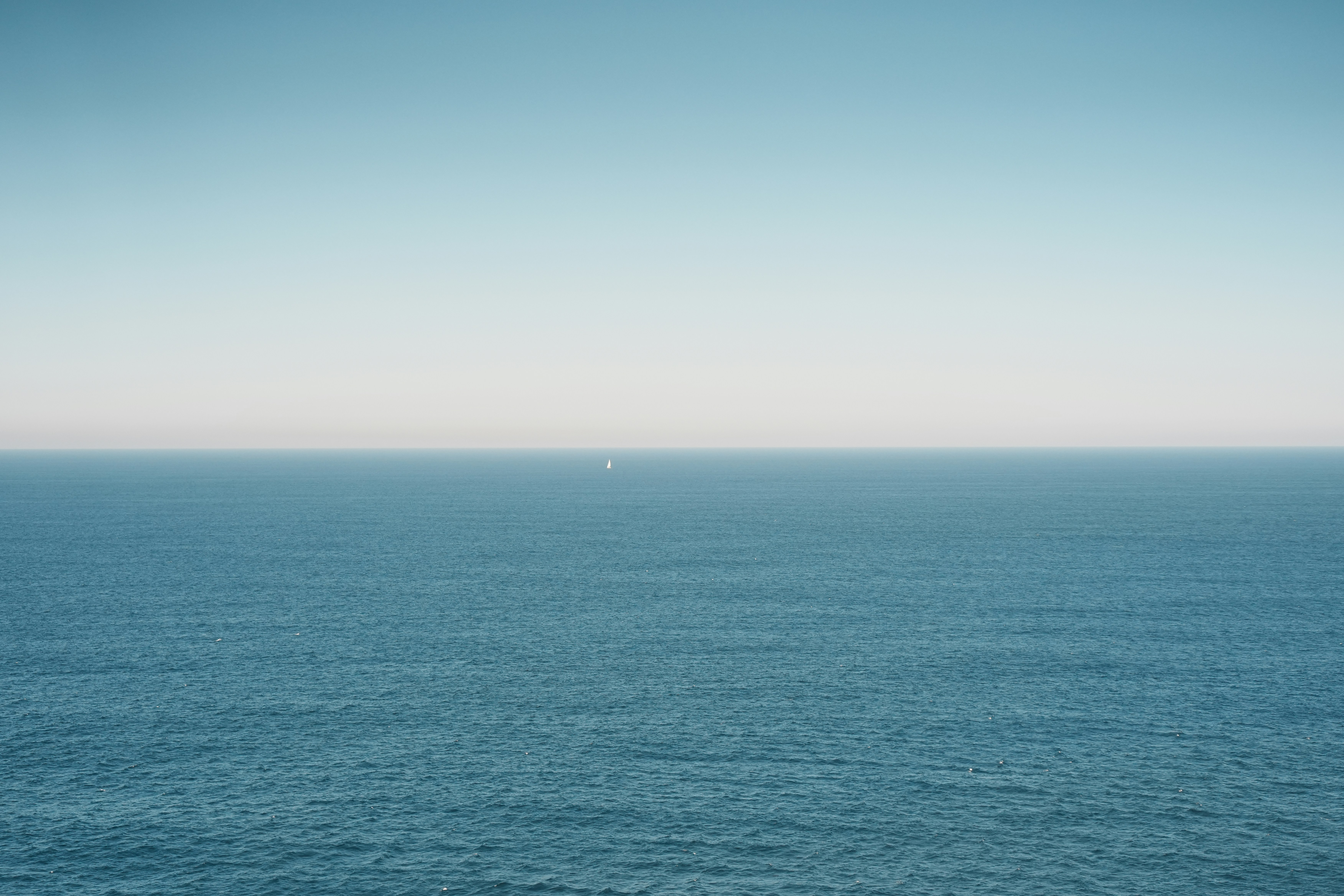 Midday Horizon: A Serene Sea with a Distant Vessel
