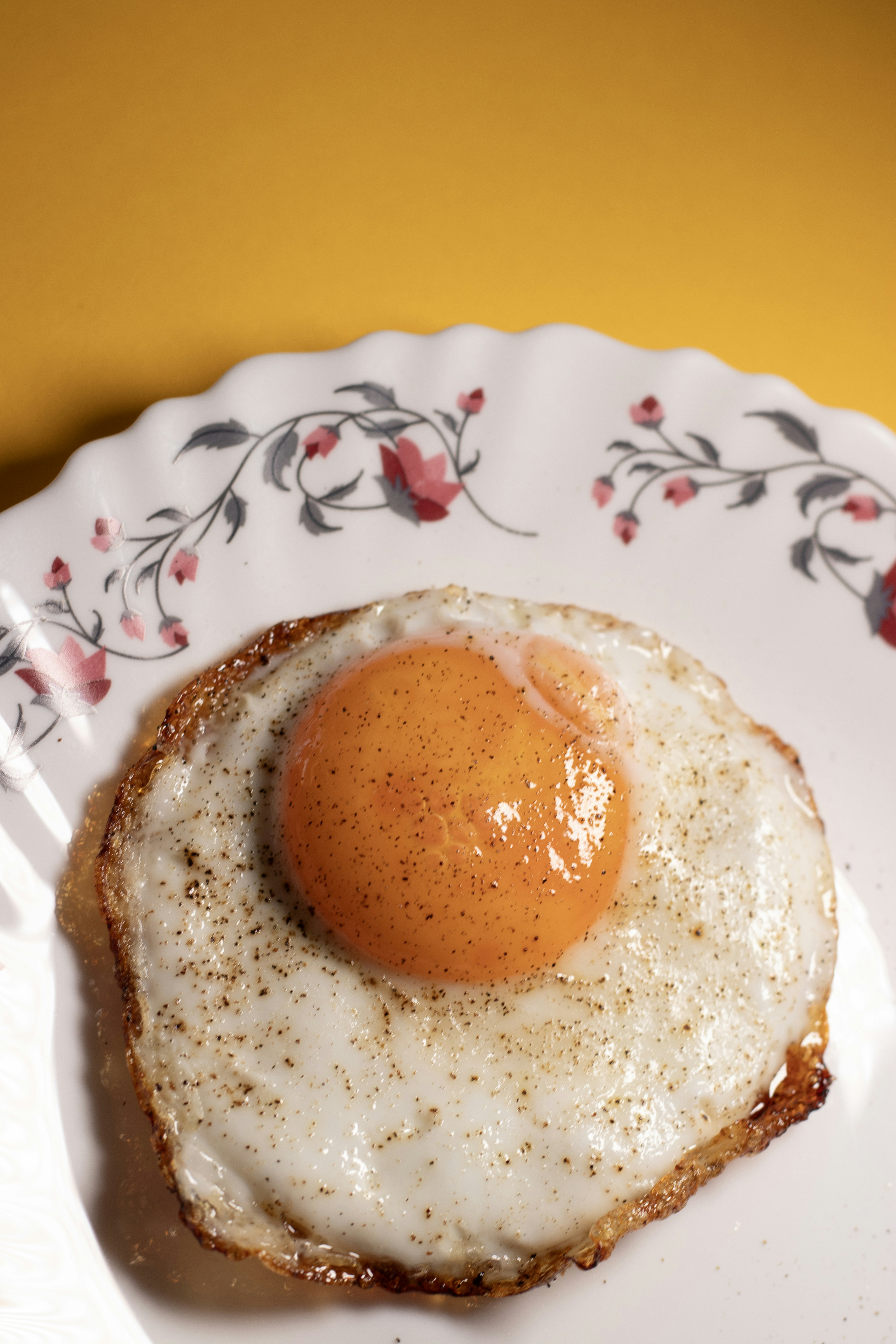 Sunny-side Focus: A Golden Egg on Floral White