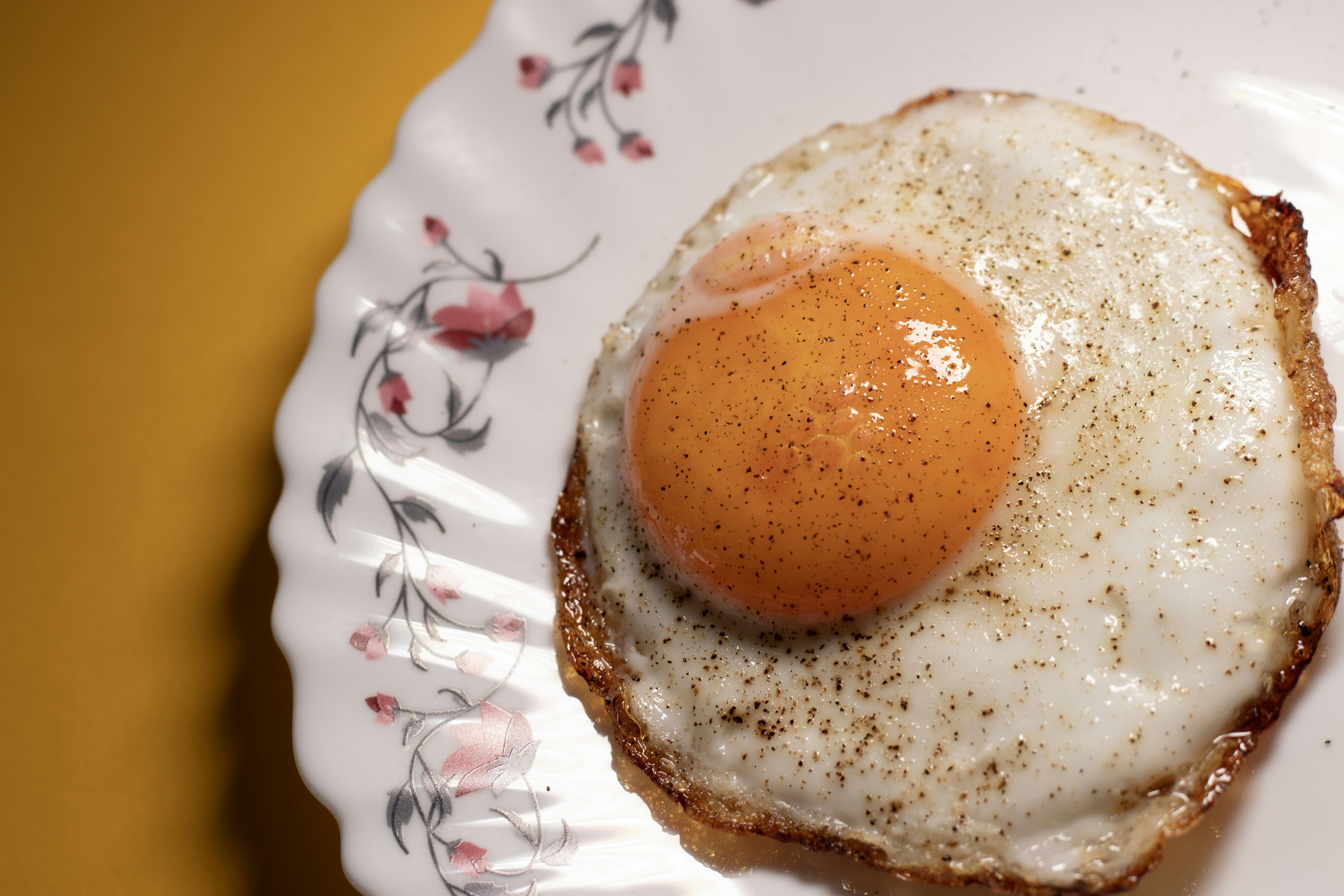 Sunlit Egg on Floral Plate: A Golden Centerpiece