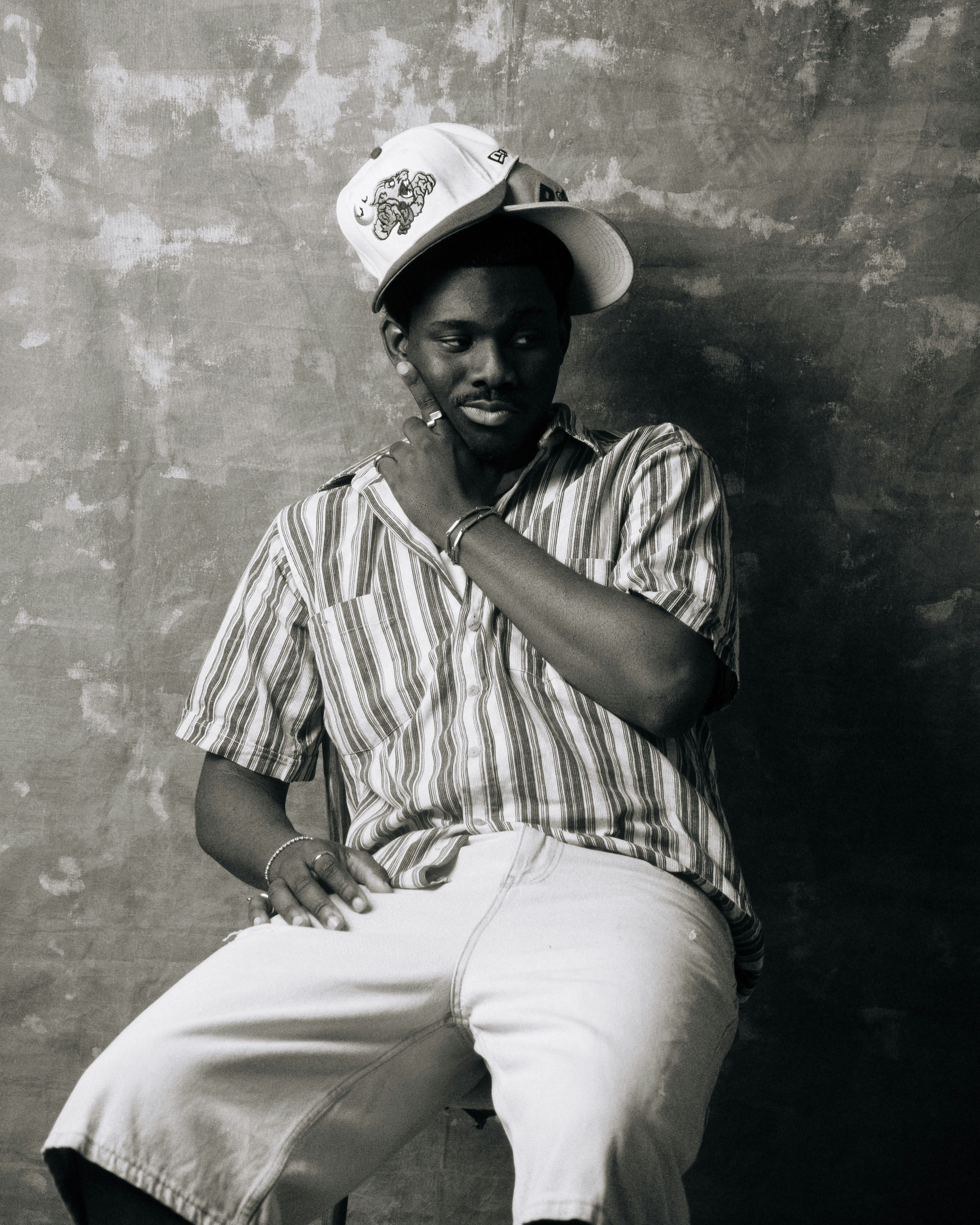 Contemplative Portrait in Striped Shirt and Cap