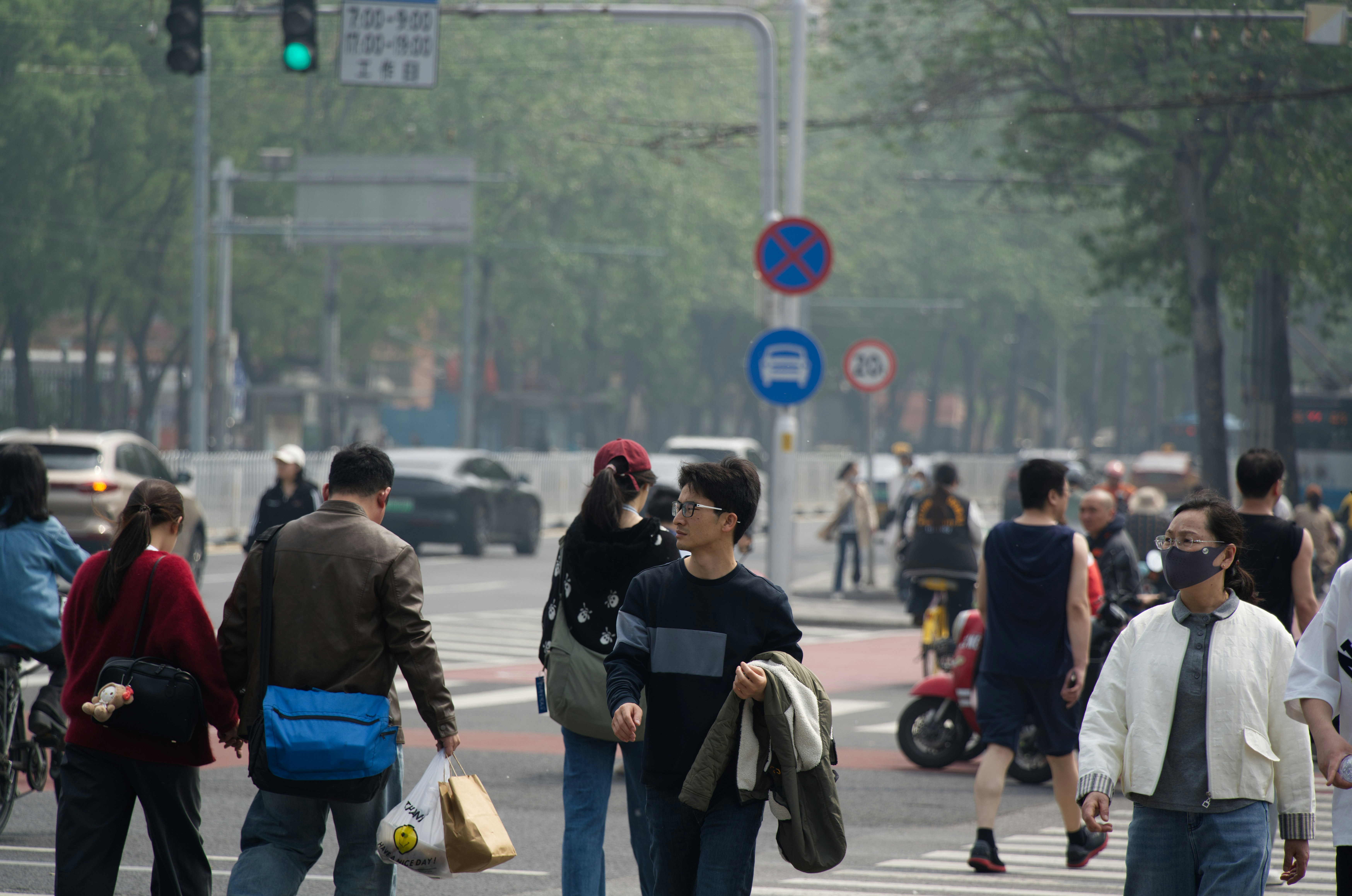 Crossing Signals: People Pause at a Bustling City Intersection